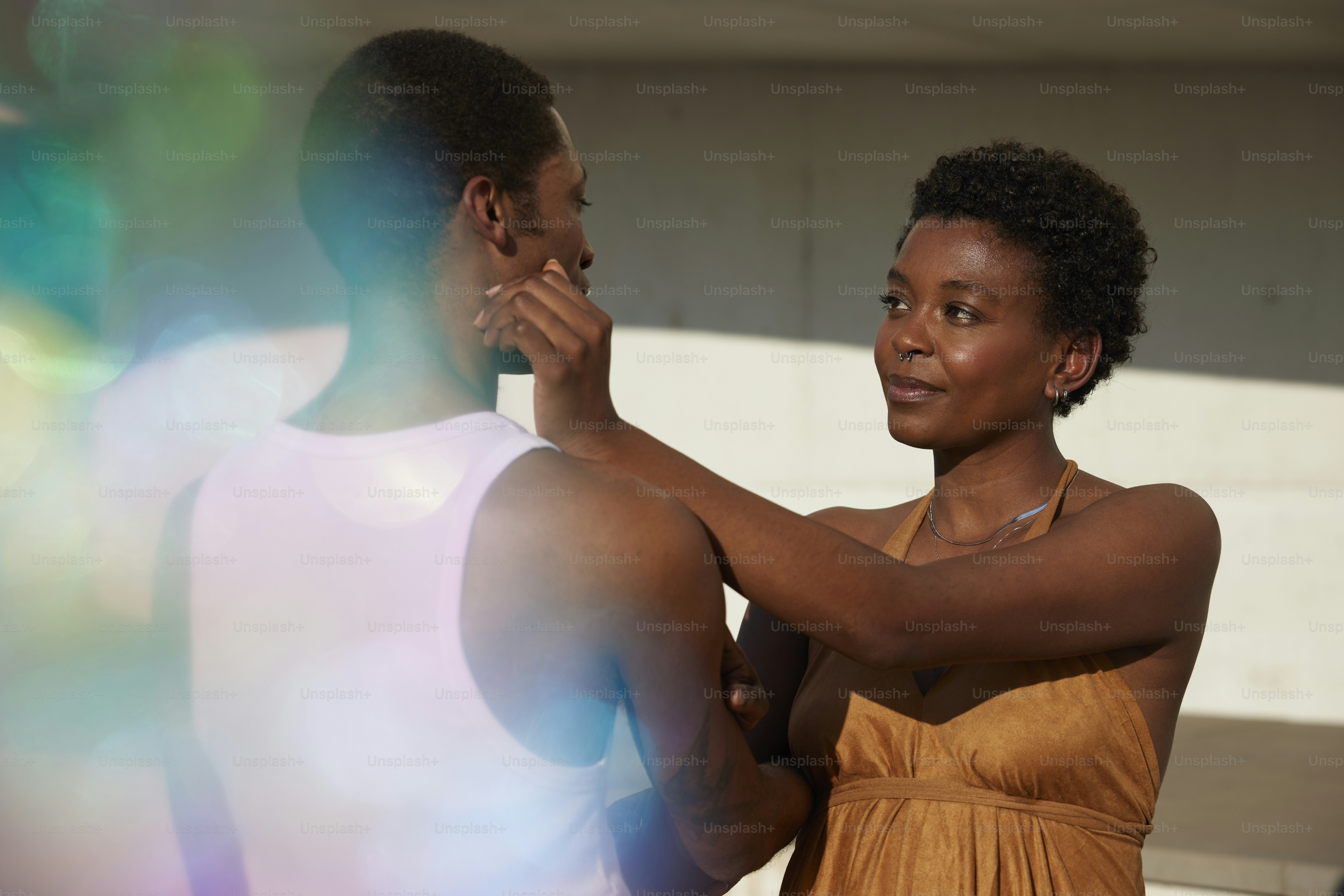 A woman helping another woman put on her necklace photo – Together ...