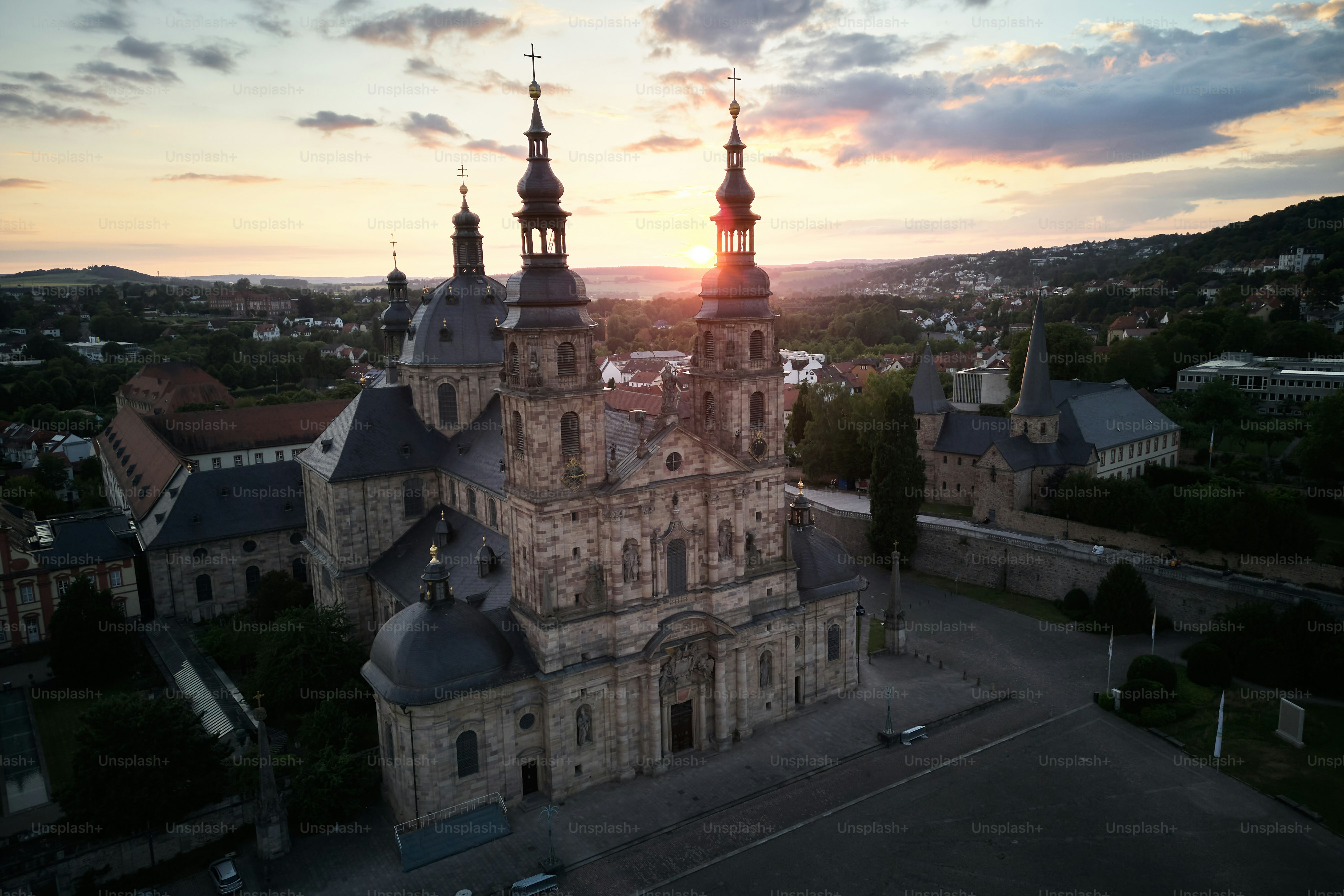 An aerial view of a church with a sunset in the background photo ...