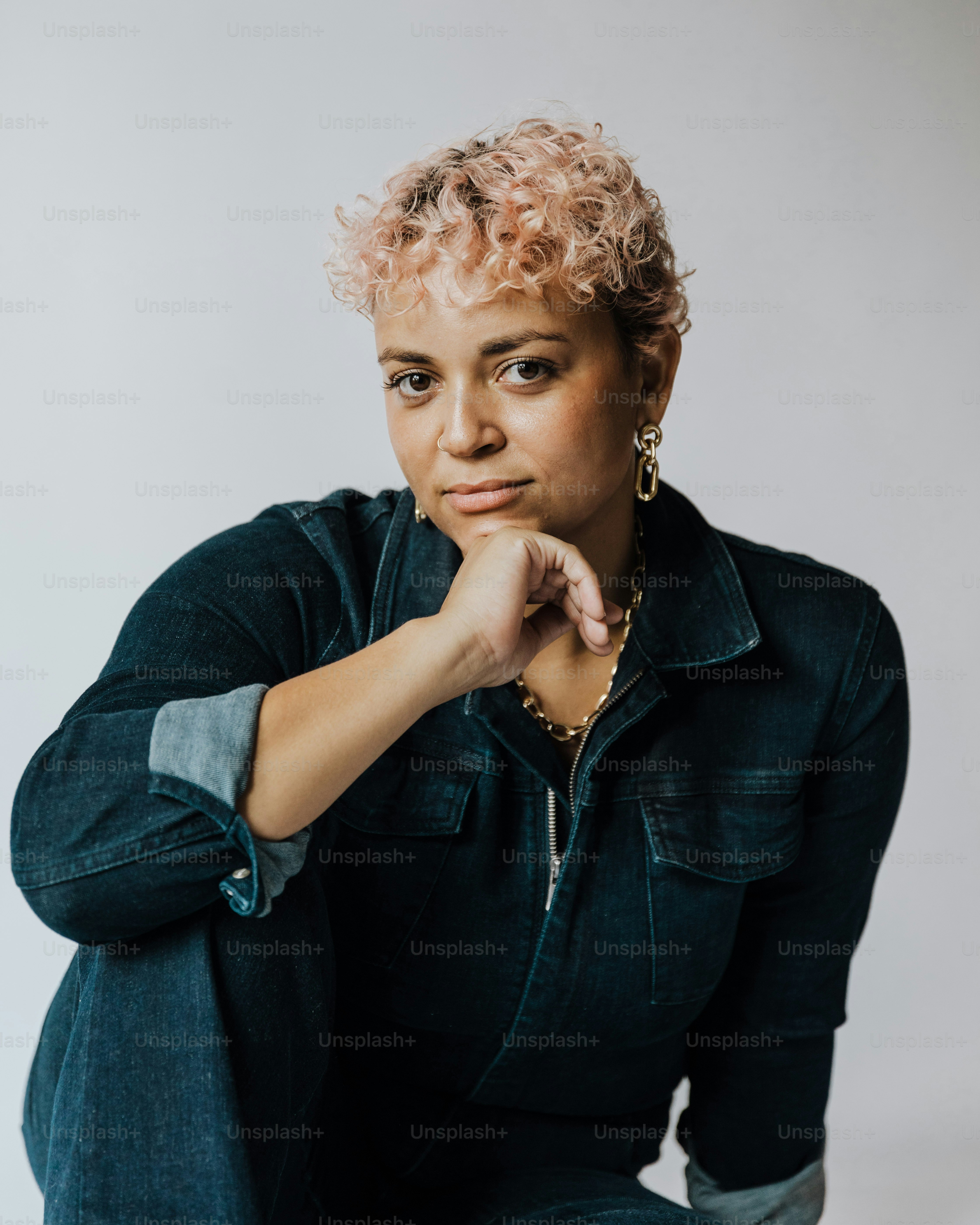 A woman sitting on the ground with her hand on her chin photo ...