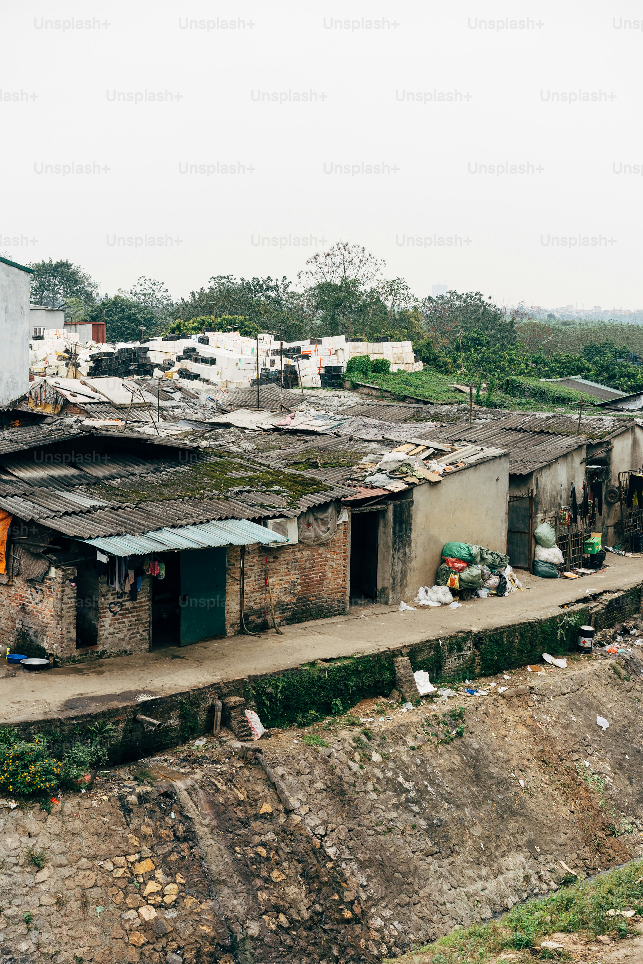 A dirt road leading to a small shack photo – Poor house Image on Unsplash