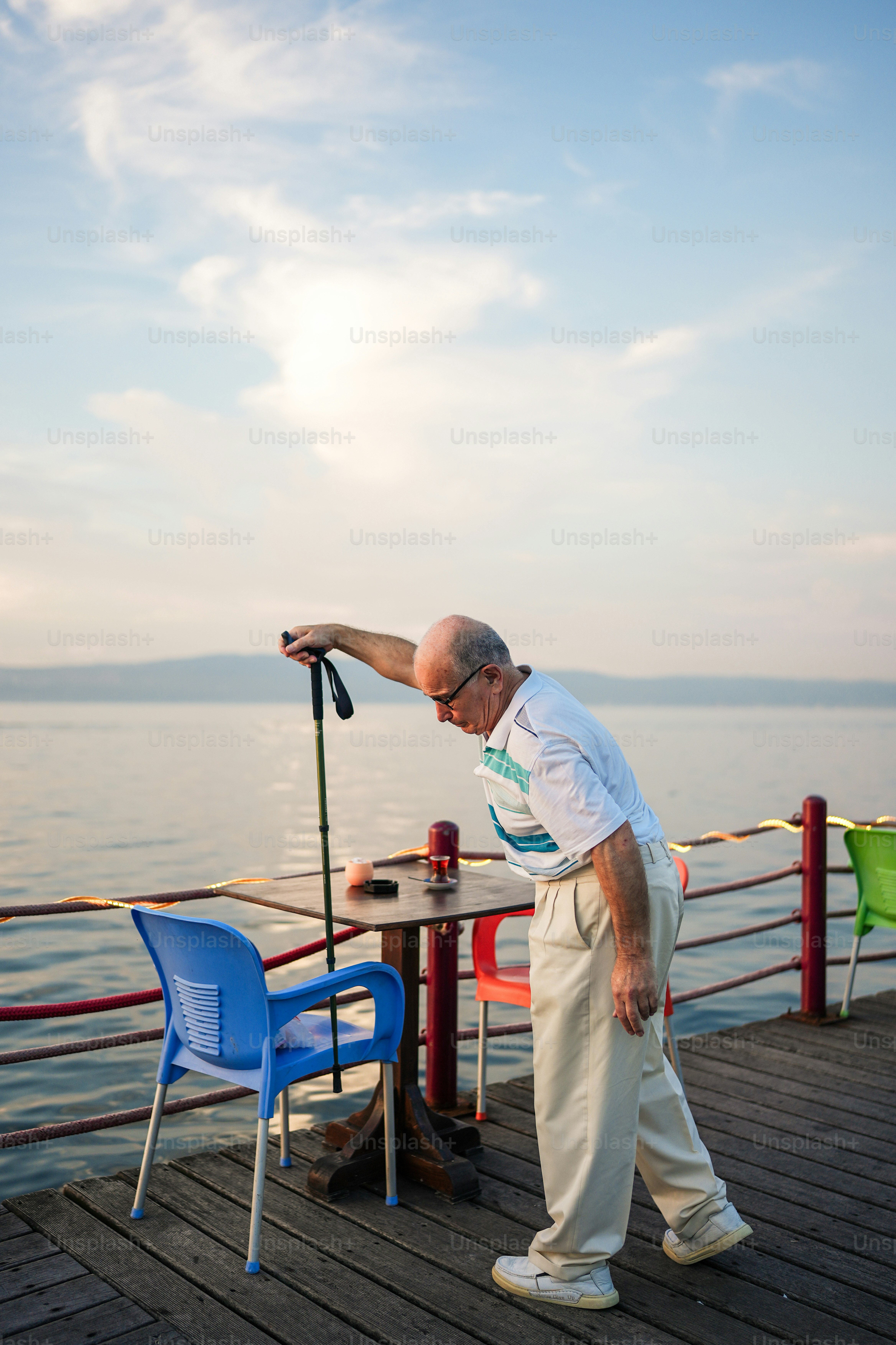 A man standing next to a table on a pier photo – Senior Image on Unsplash