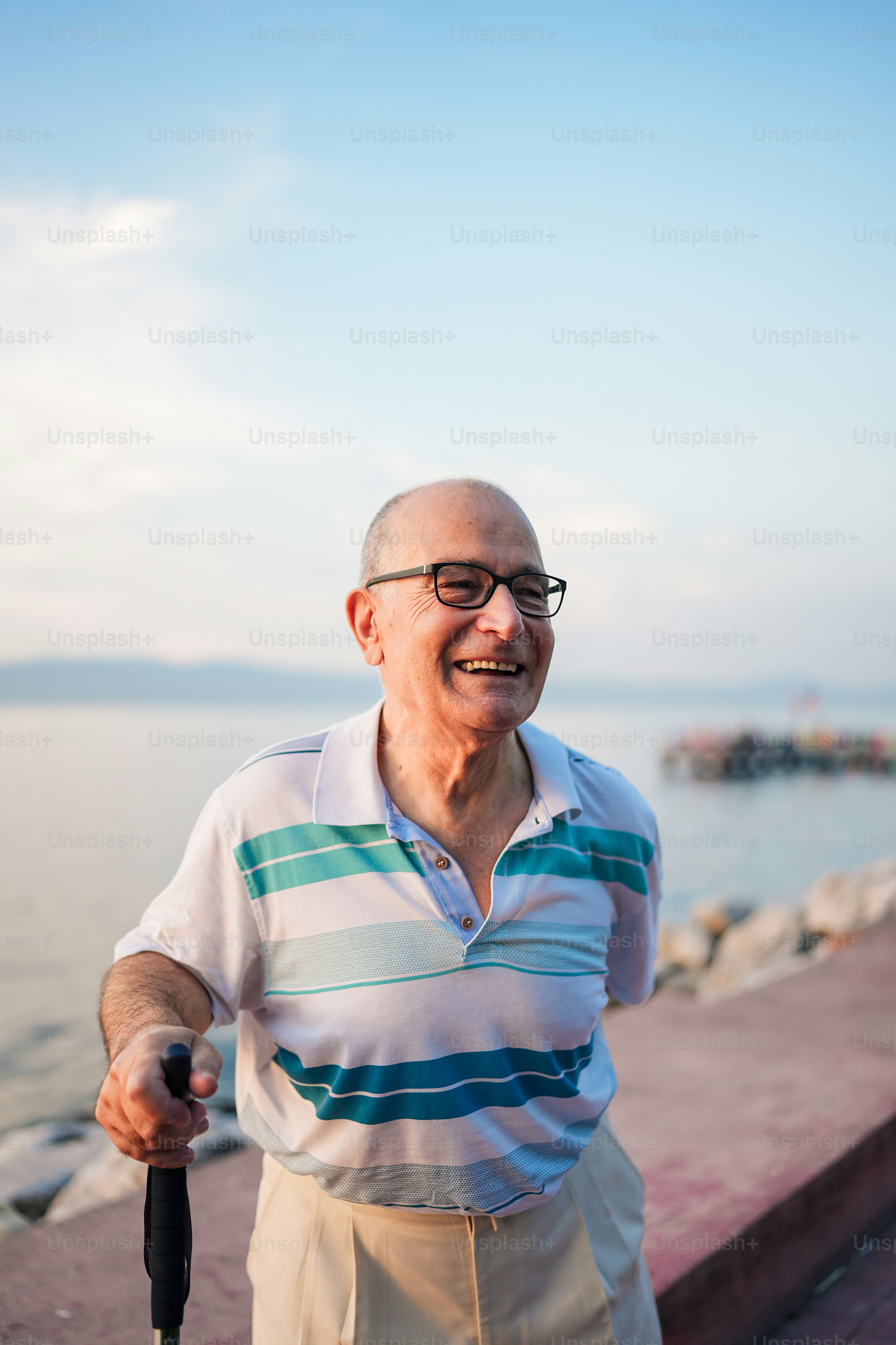 An older man holding an umbrella near the water photo – Old man Image ...