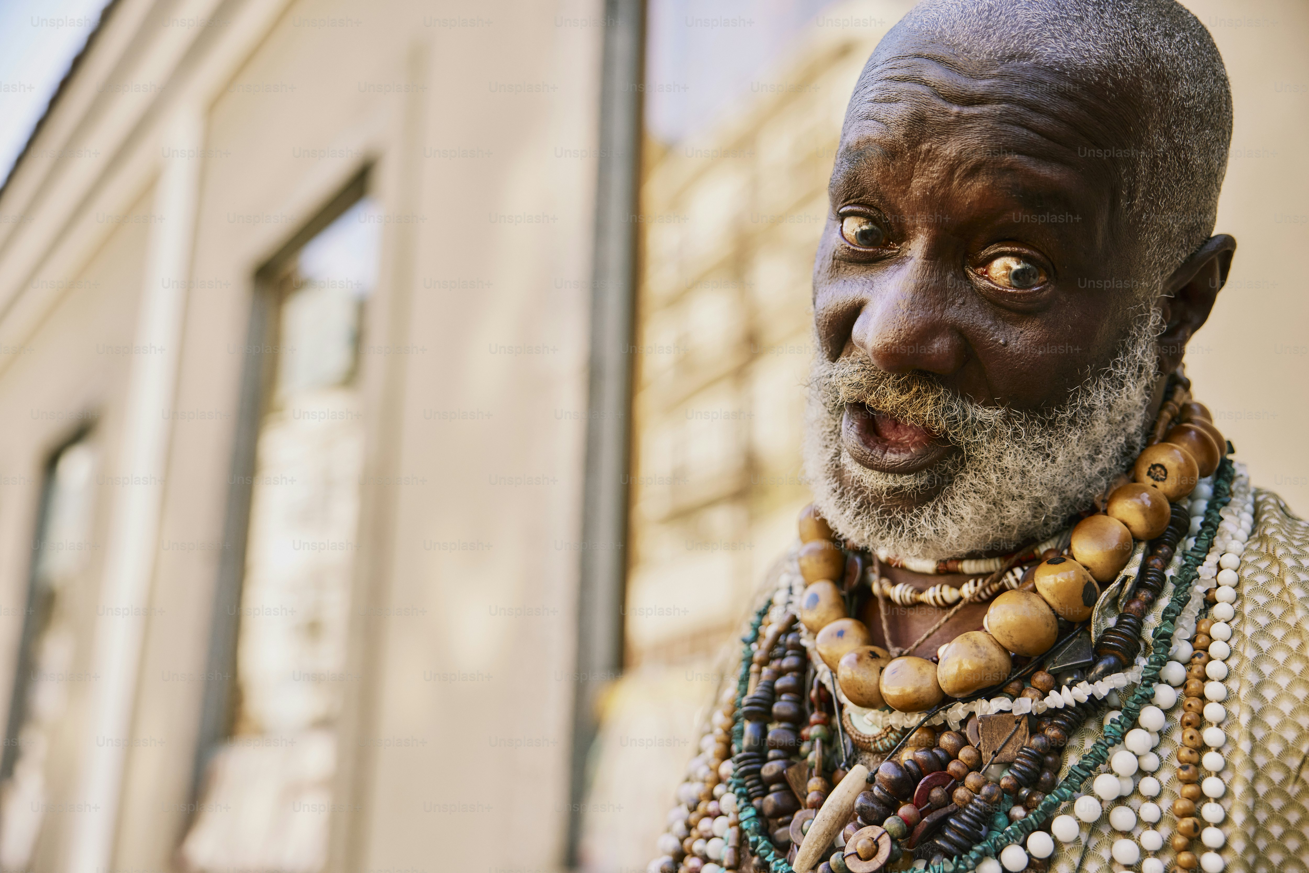 An old man with a beard and necklaces photo – Black Image on Unsplash