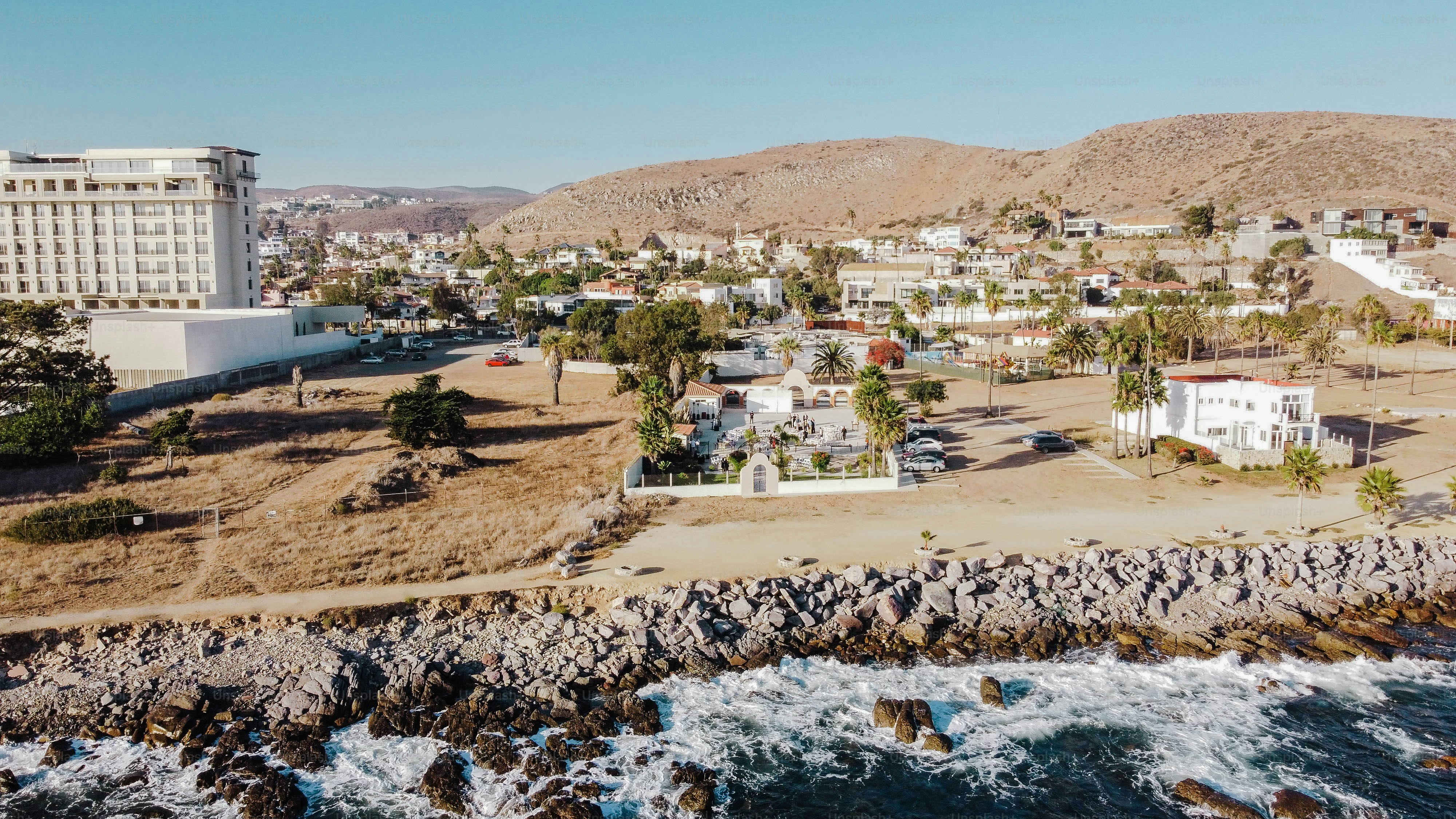 Una vista aérea de una playa con un hotel al fondo foto – Imagen de ...