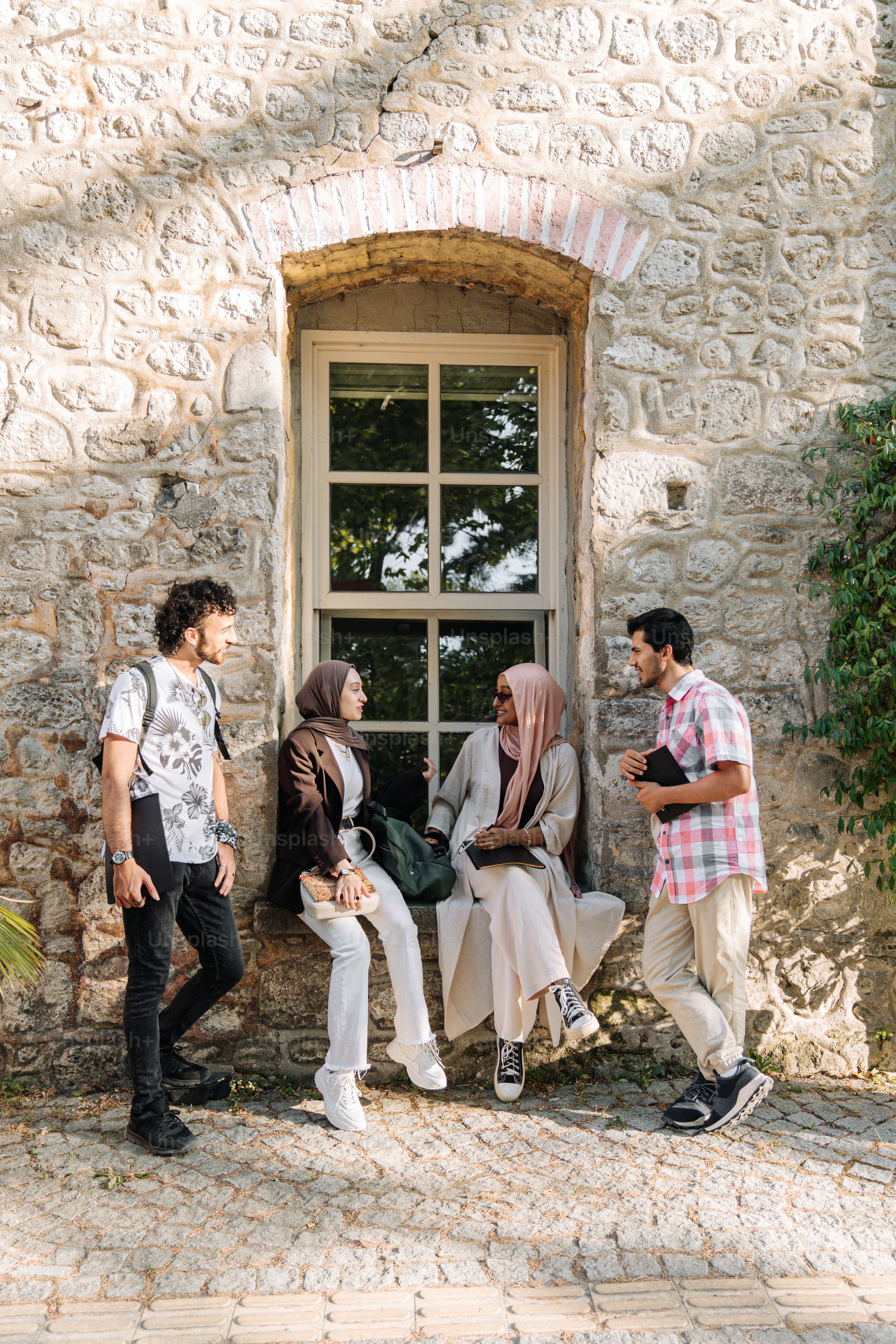 A group of people standing next to a window photo – College girl Image ...