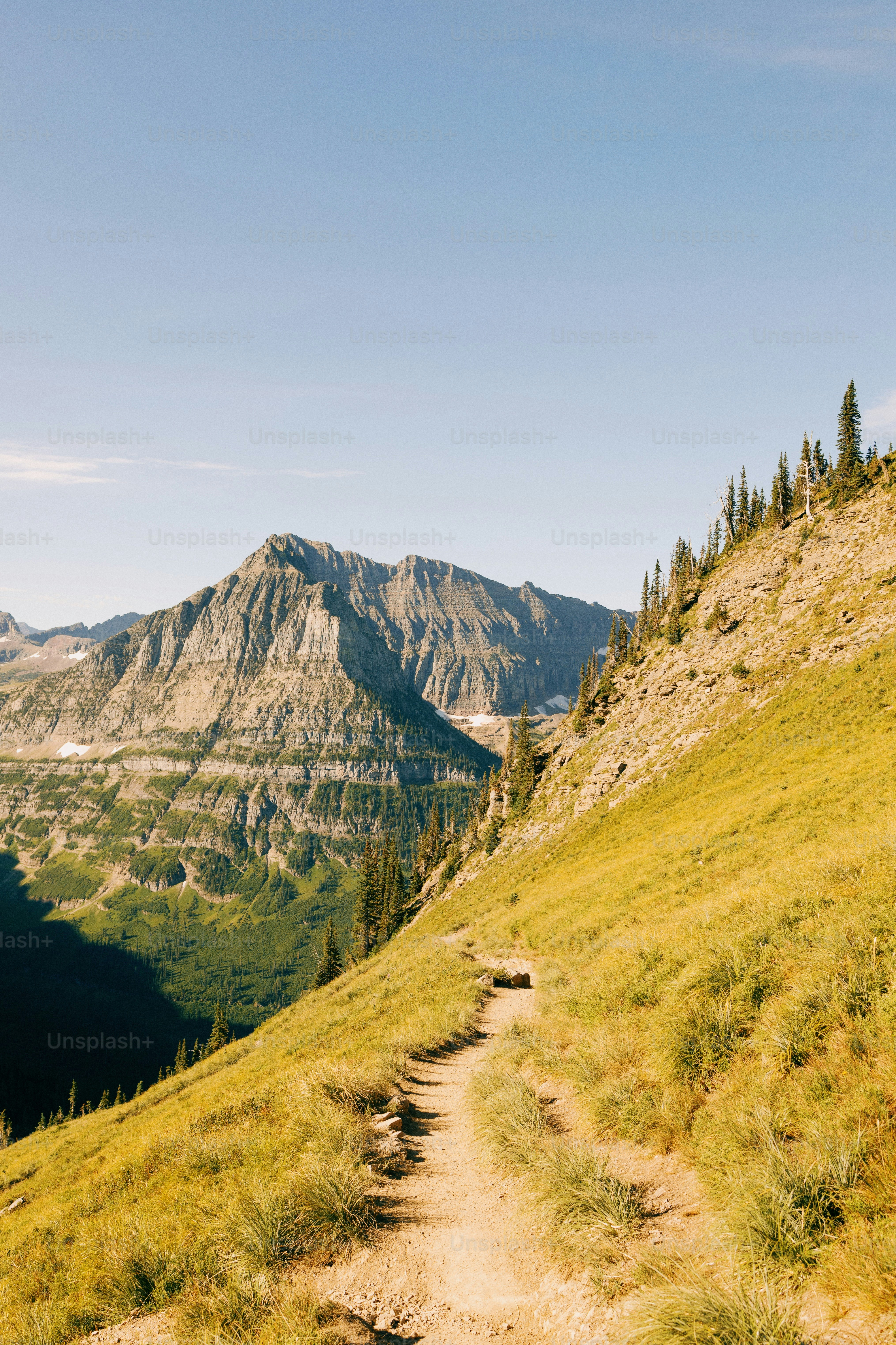A dirt path going up a hill with mountains in the background photo ...