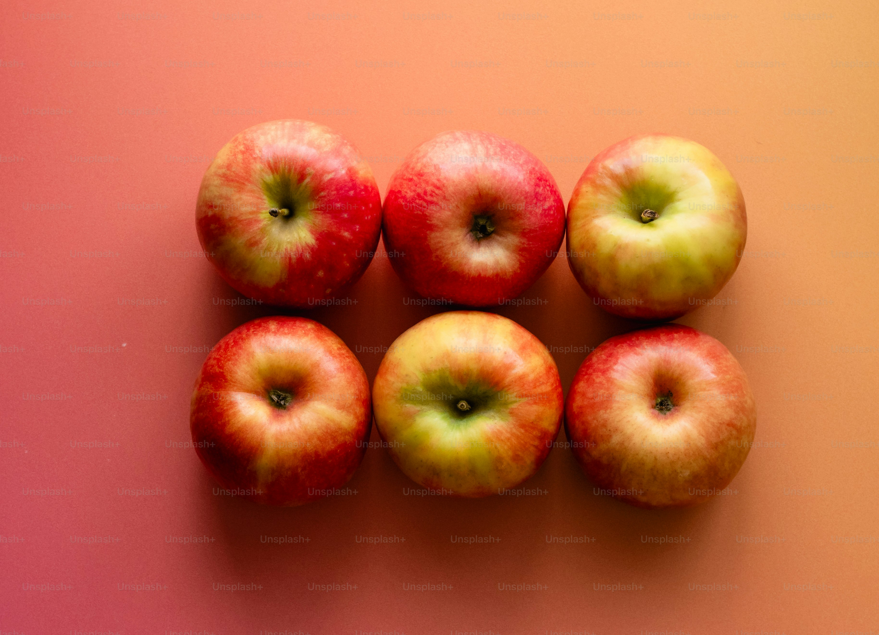 A group of five apples sitting on top of a pink surface 사진 – Unsplash의 ...