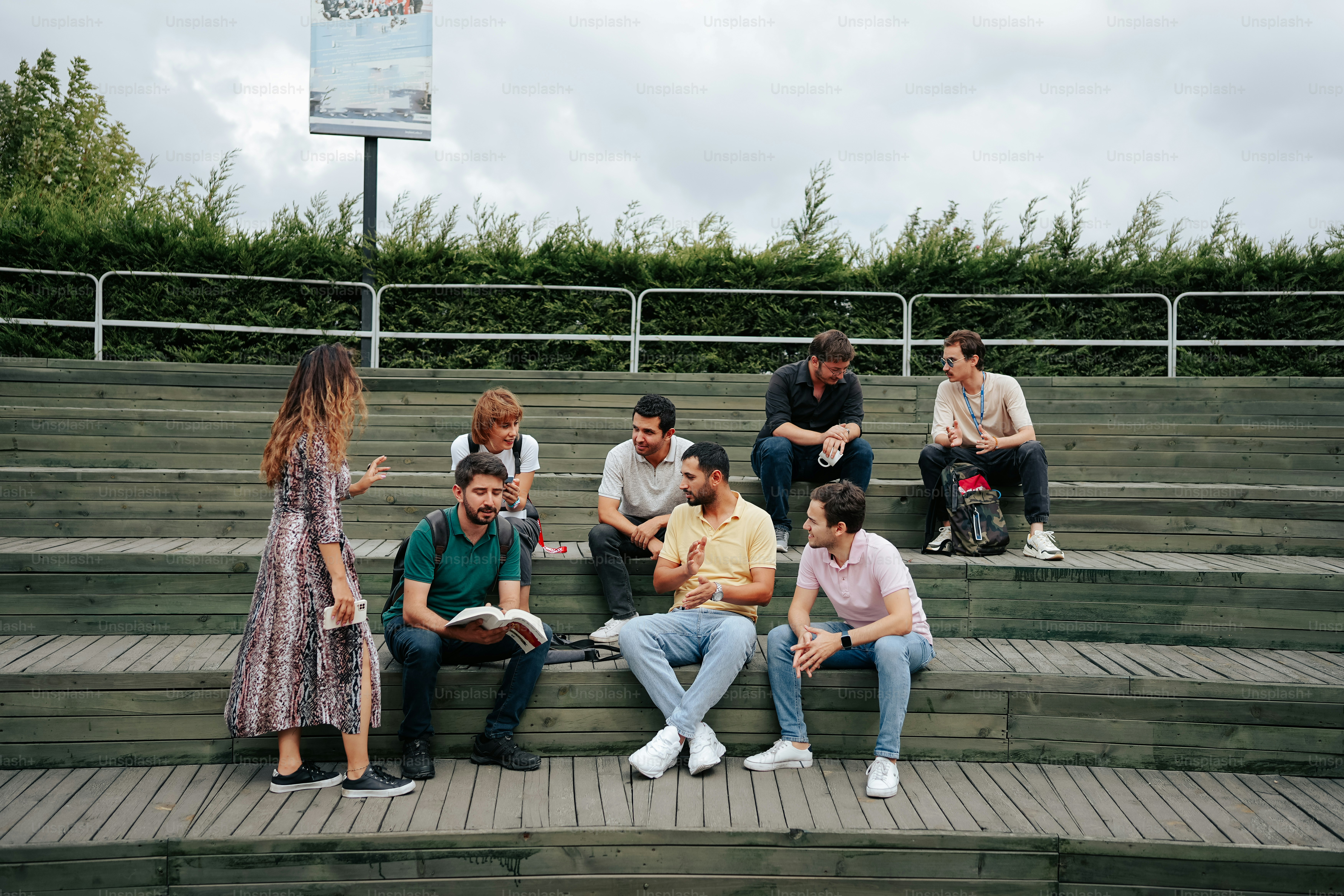 A group of people sitting on the bleachers photo – University Image on ...