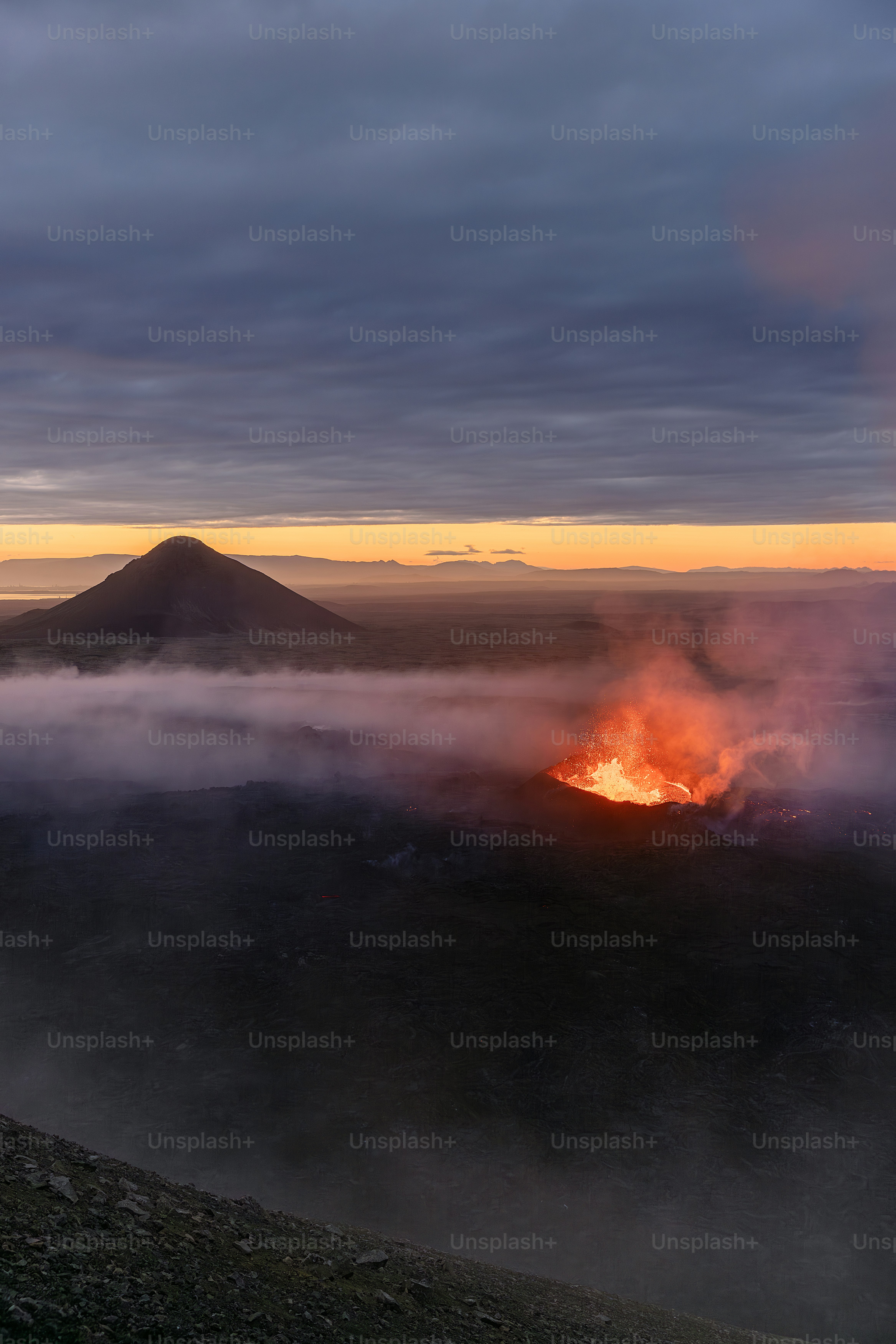 A volcano spewing out lava in the distance photo – Lava Image on Unsplash