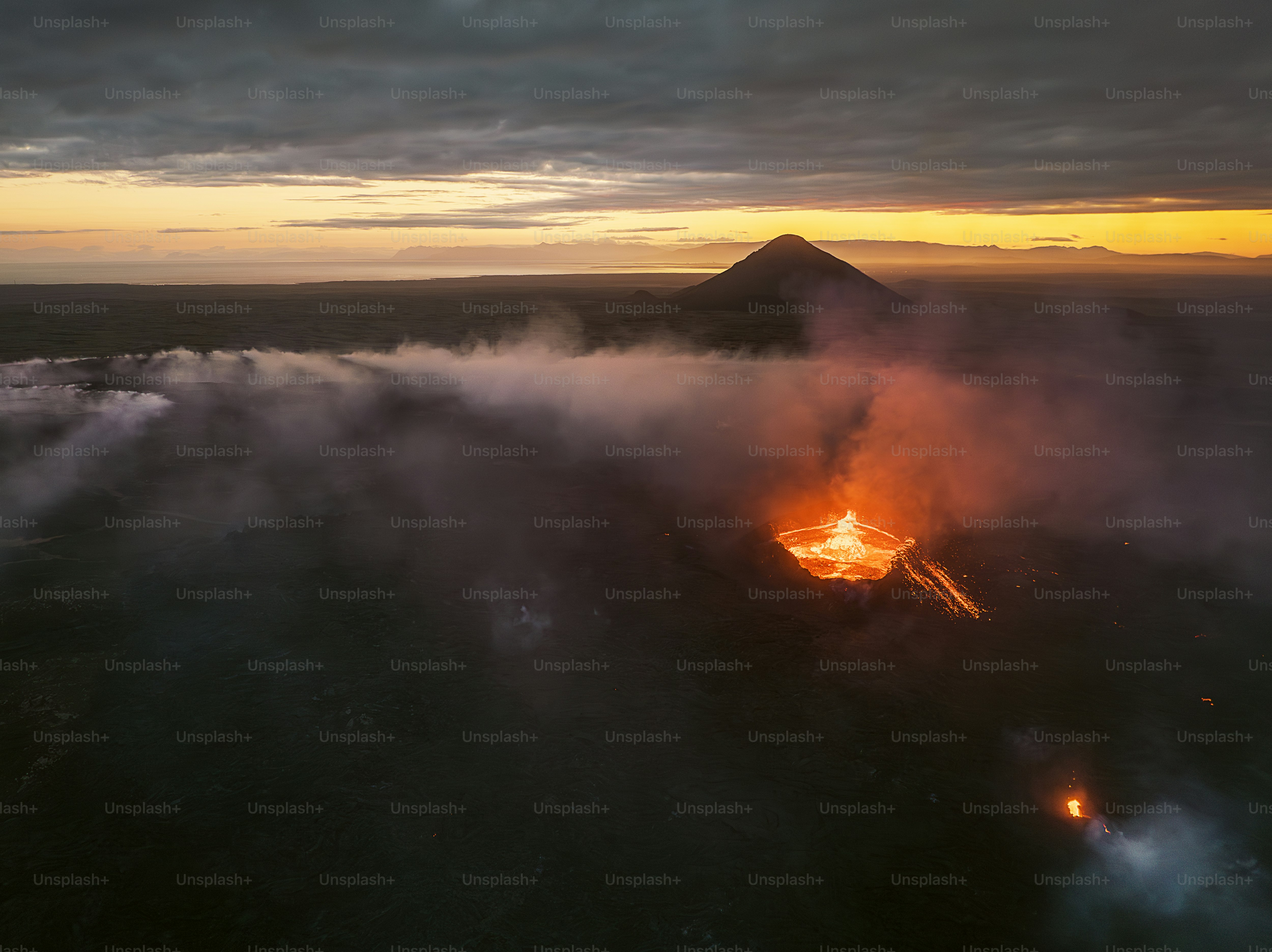 An aerial view of a volcano in the middle of the night photo – Volcano ...
