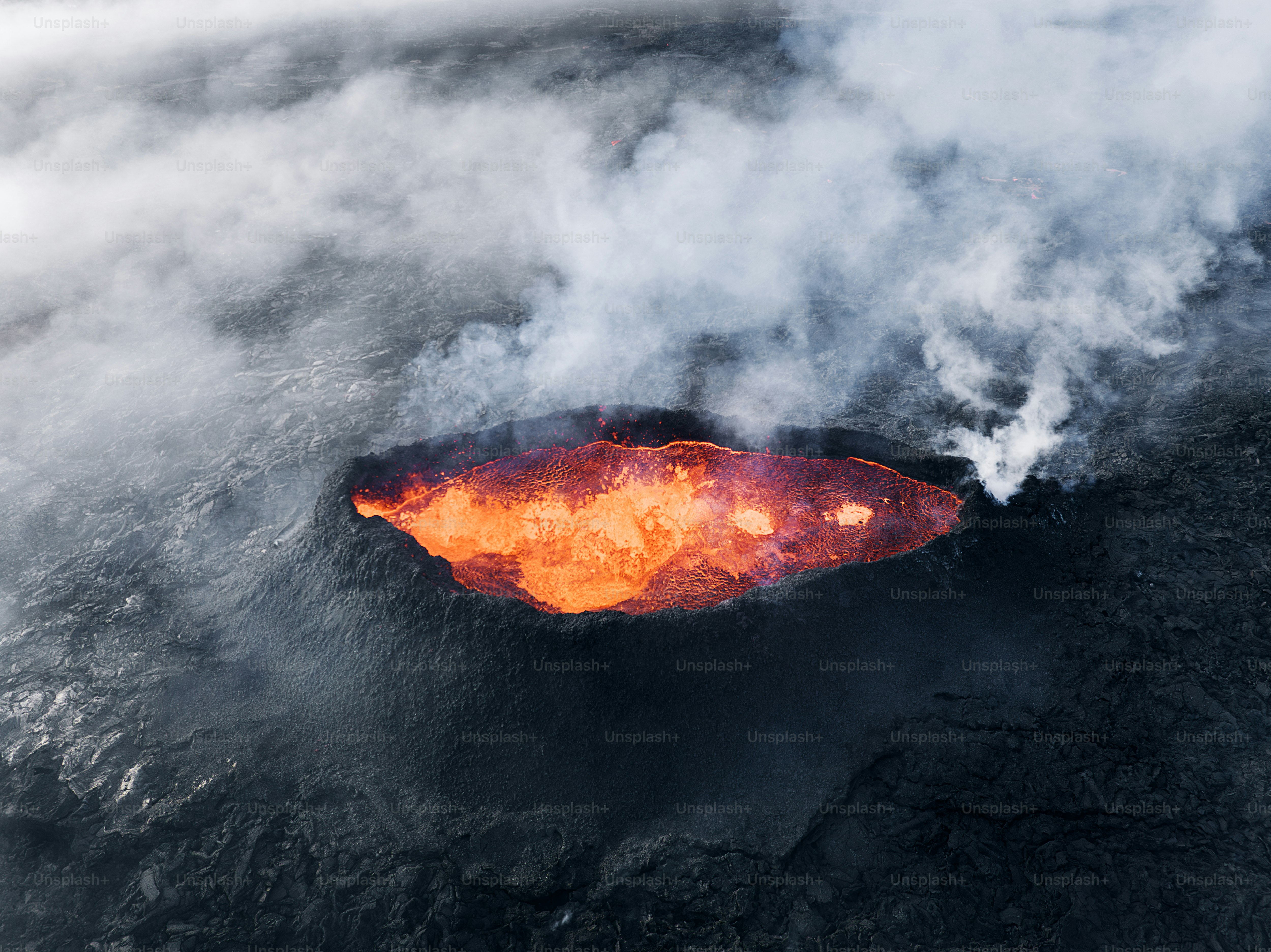 An aerial view of an active volcano in the ocean photo – Wallpaper ...