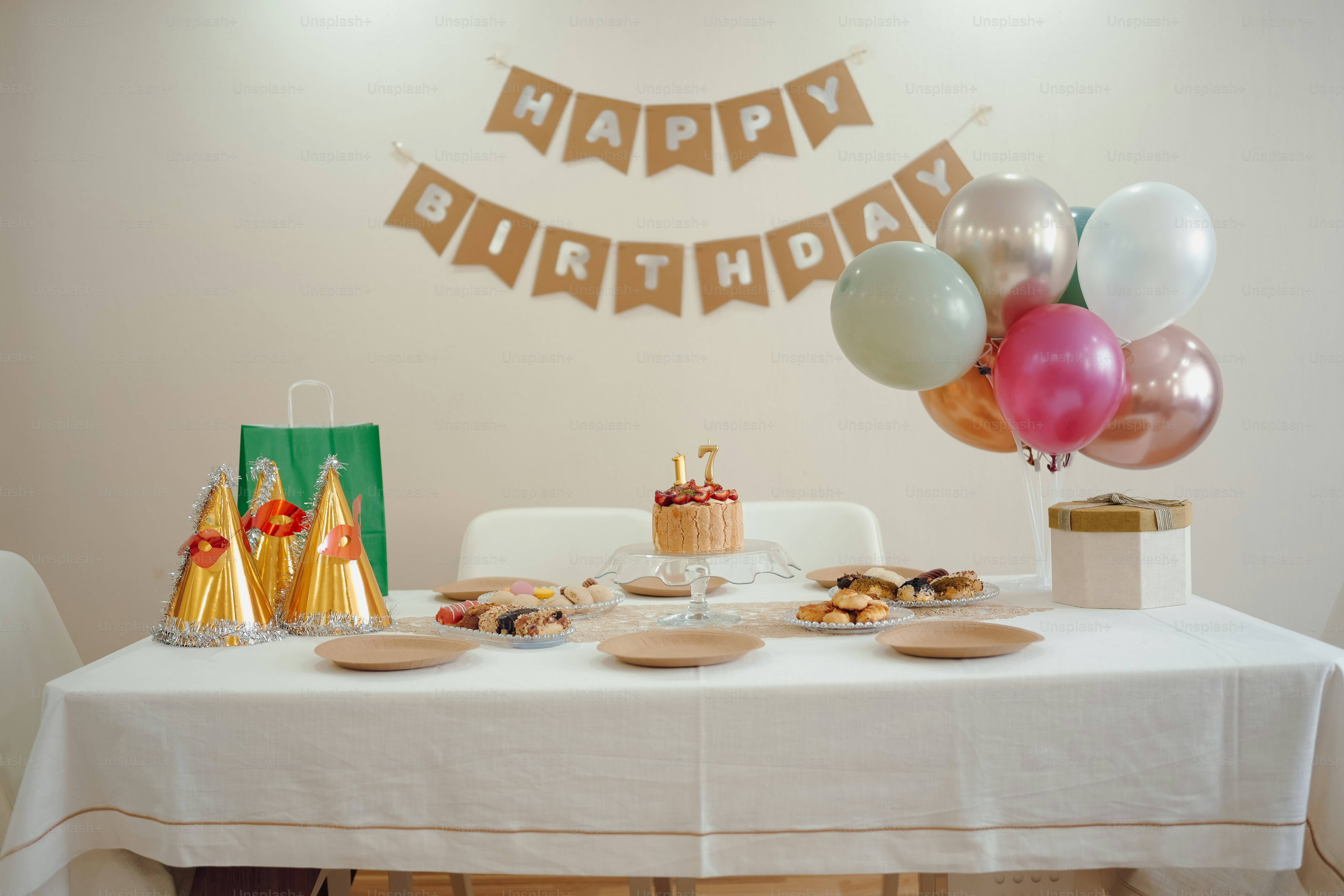 A white table topped with a cake and lots of balloons photo – Birthday ...