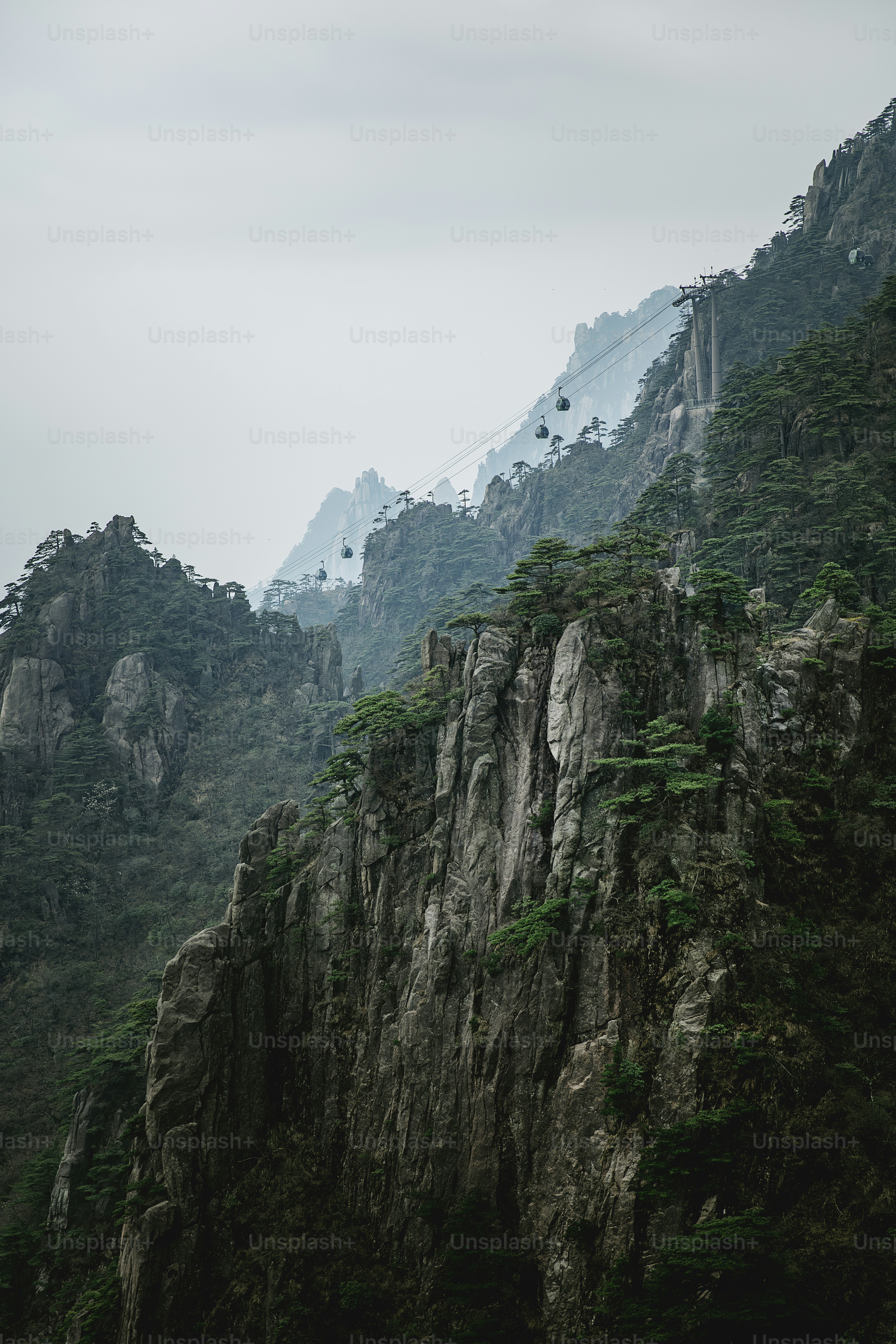 A view of a mountain range with pine trees on top of it photo – Anhui ...