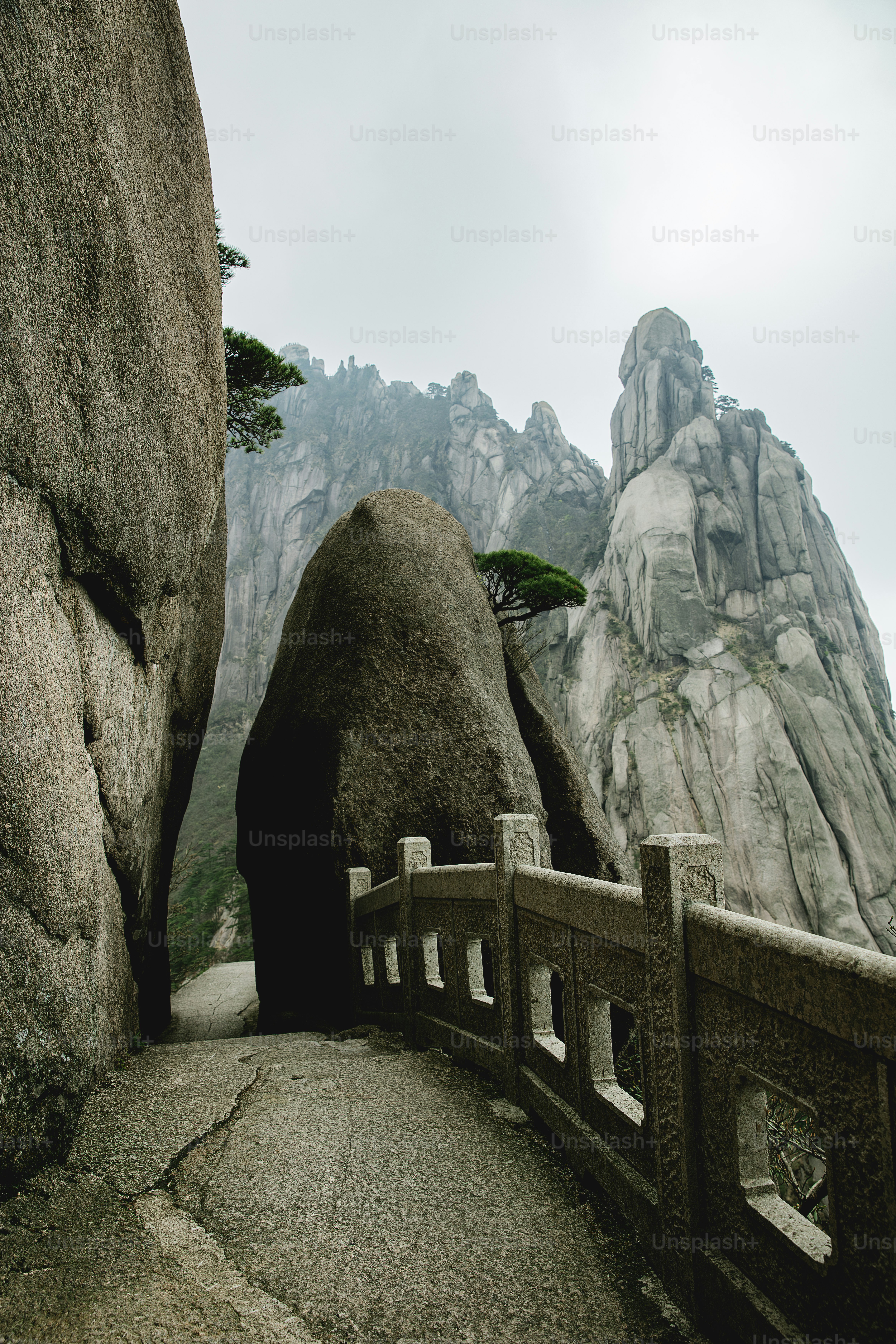 A large rock sitting next to a wooden bridge photo – Huangshan Image on ...
