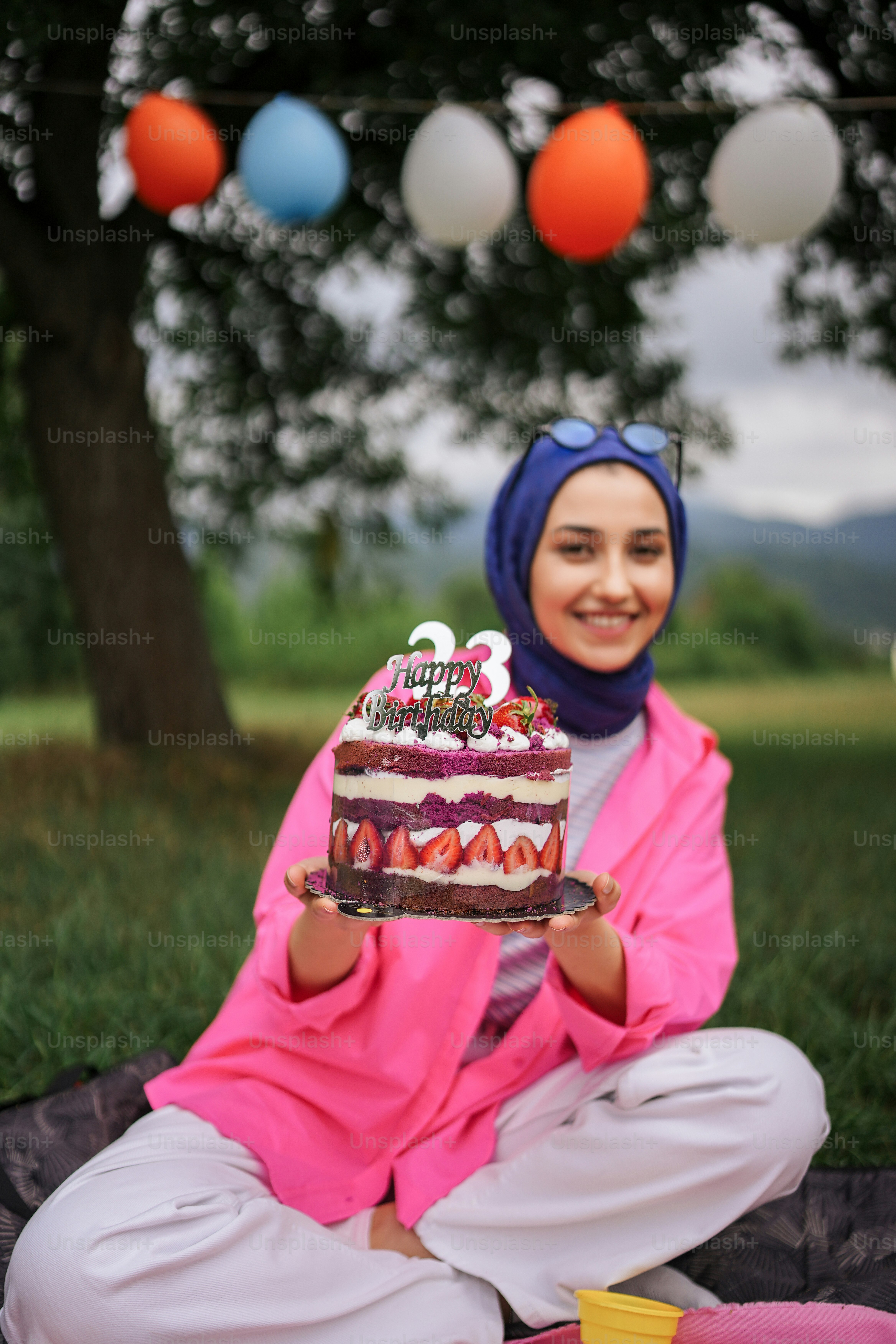 A woman in a hijab holding a birthday cake photo – Party Image on Unsplash