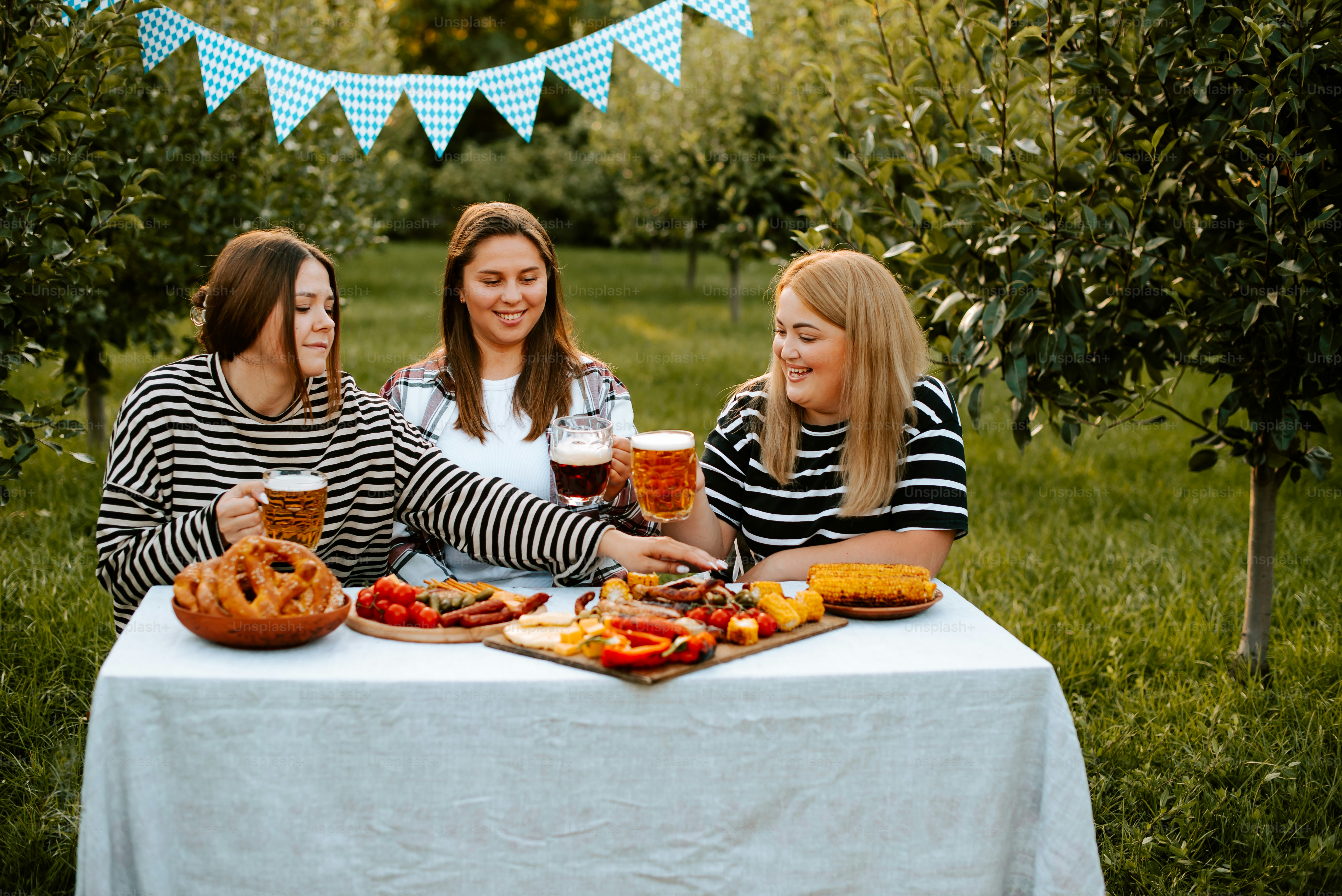 A group of women sitting around a table with food and drinks photo ...