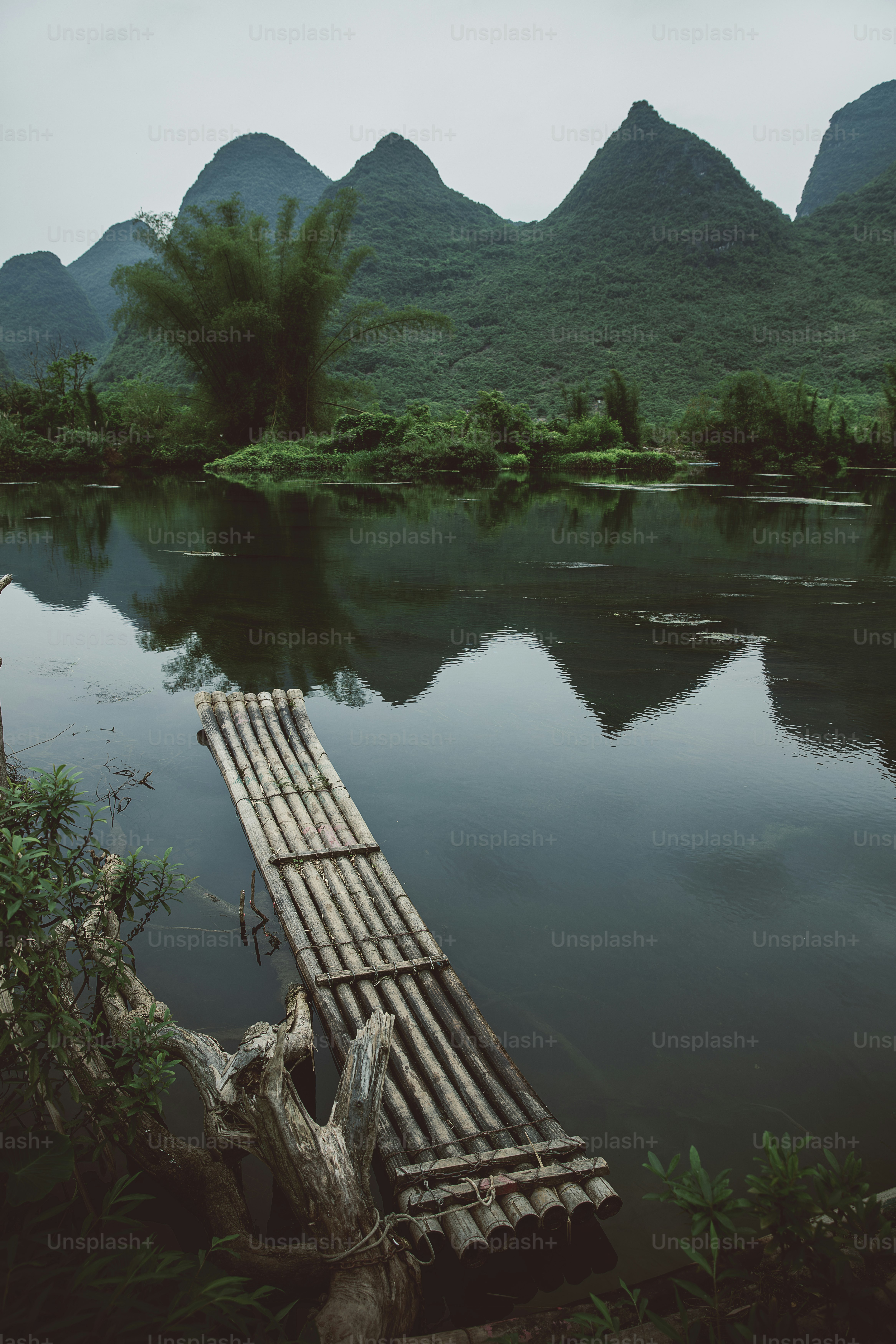 A wooden raft floating on top of a river photo – Guangxi Image on Unsplash