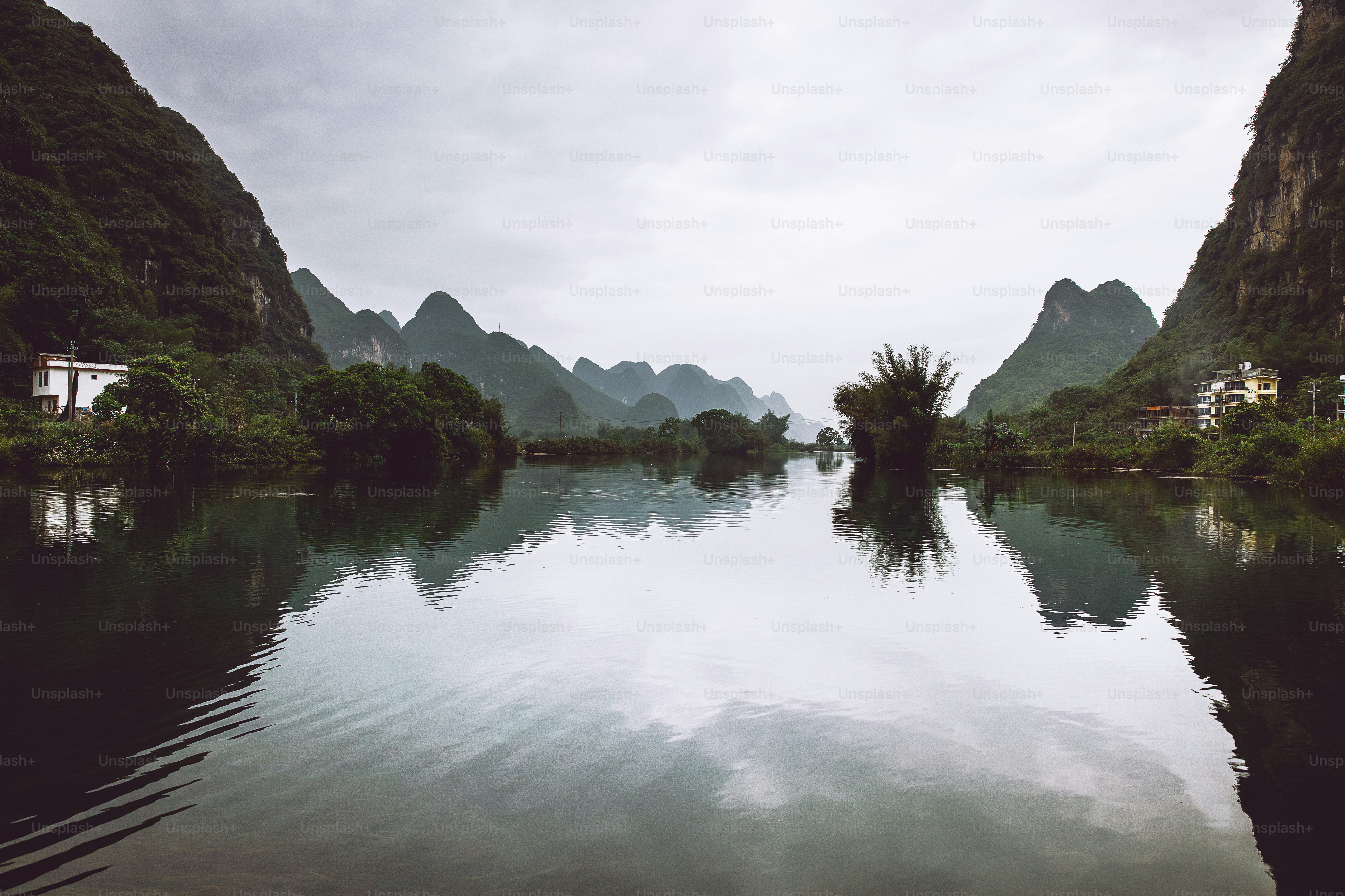 A body of water with mountains in the background photo – Guangxi Image ...