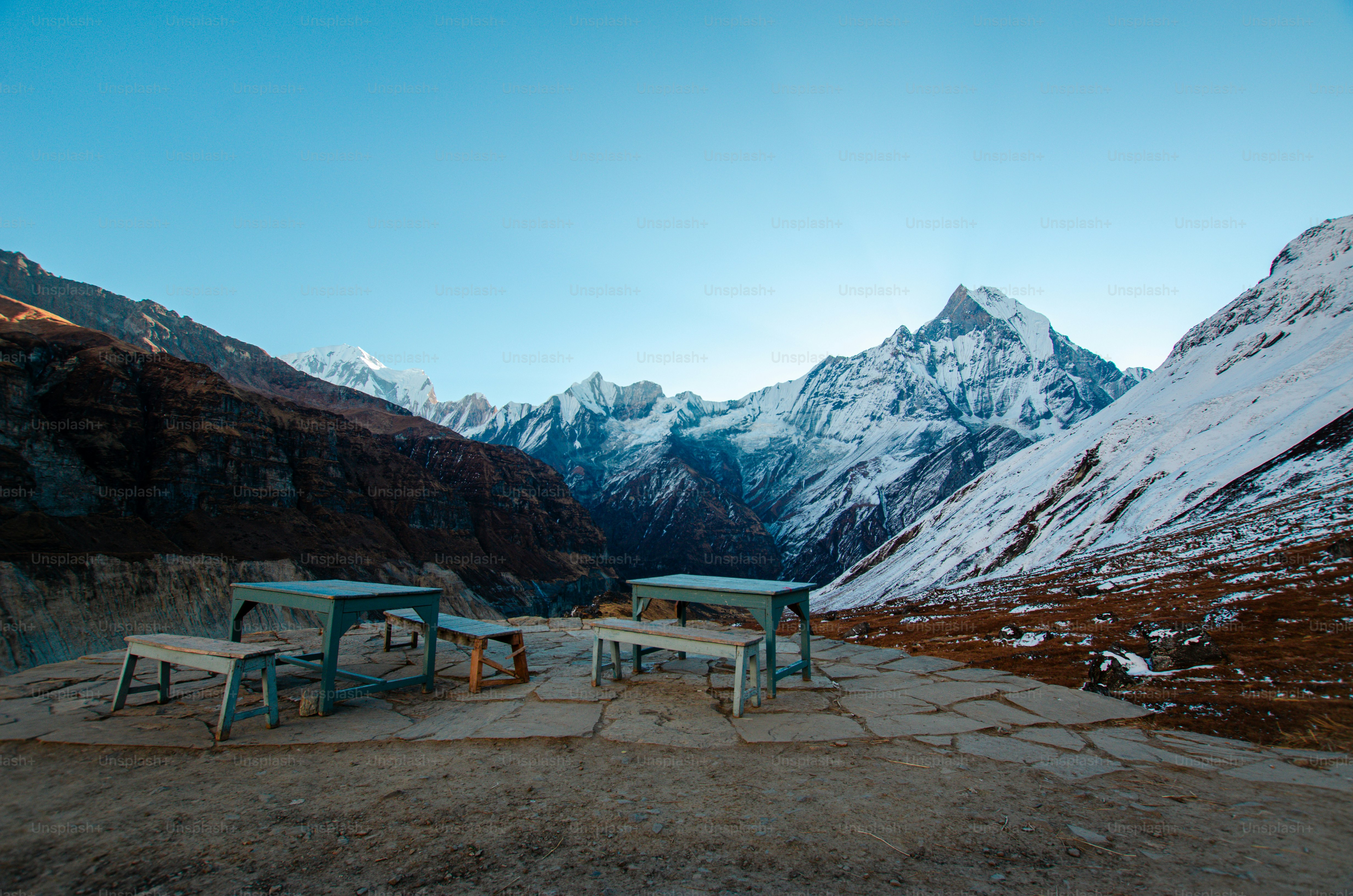 A couple of picnic tables sitting on top of a mountain photo – Nepal ...