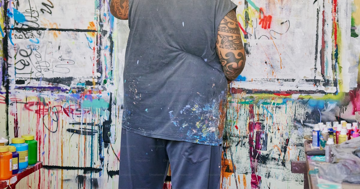 Un Homme Peignant Sur Un Mur Couvert De Graffitis Photo Art De Rue
