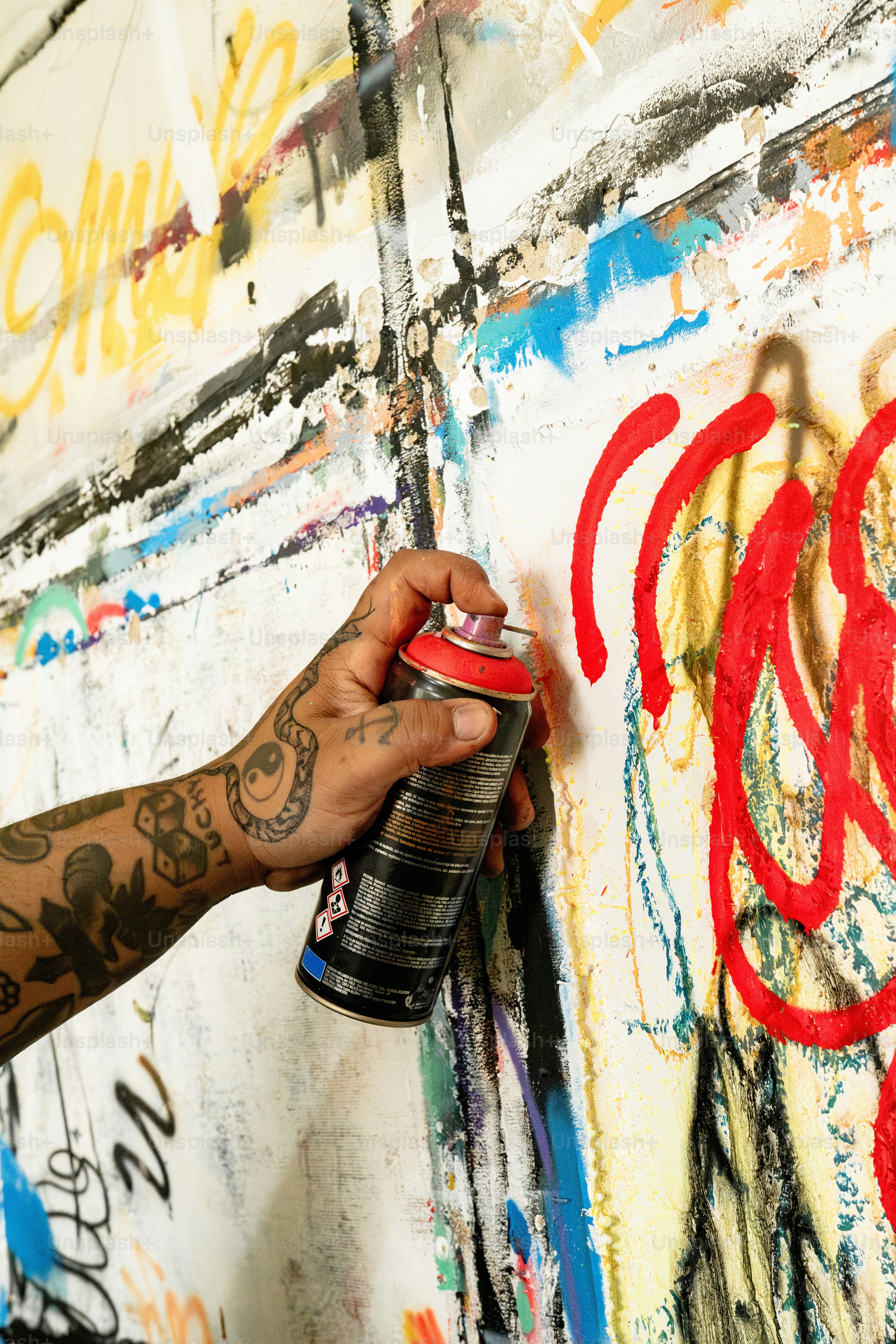 A person spray painting on a wall with graffiti photo – Graffiti Image ...