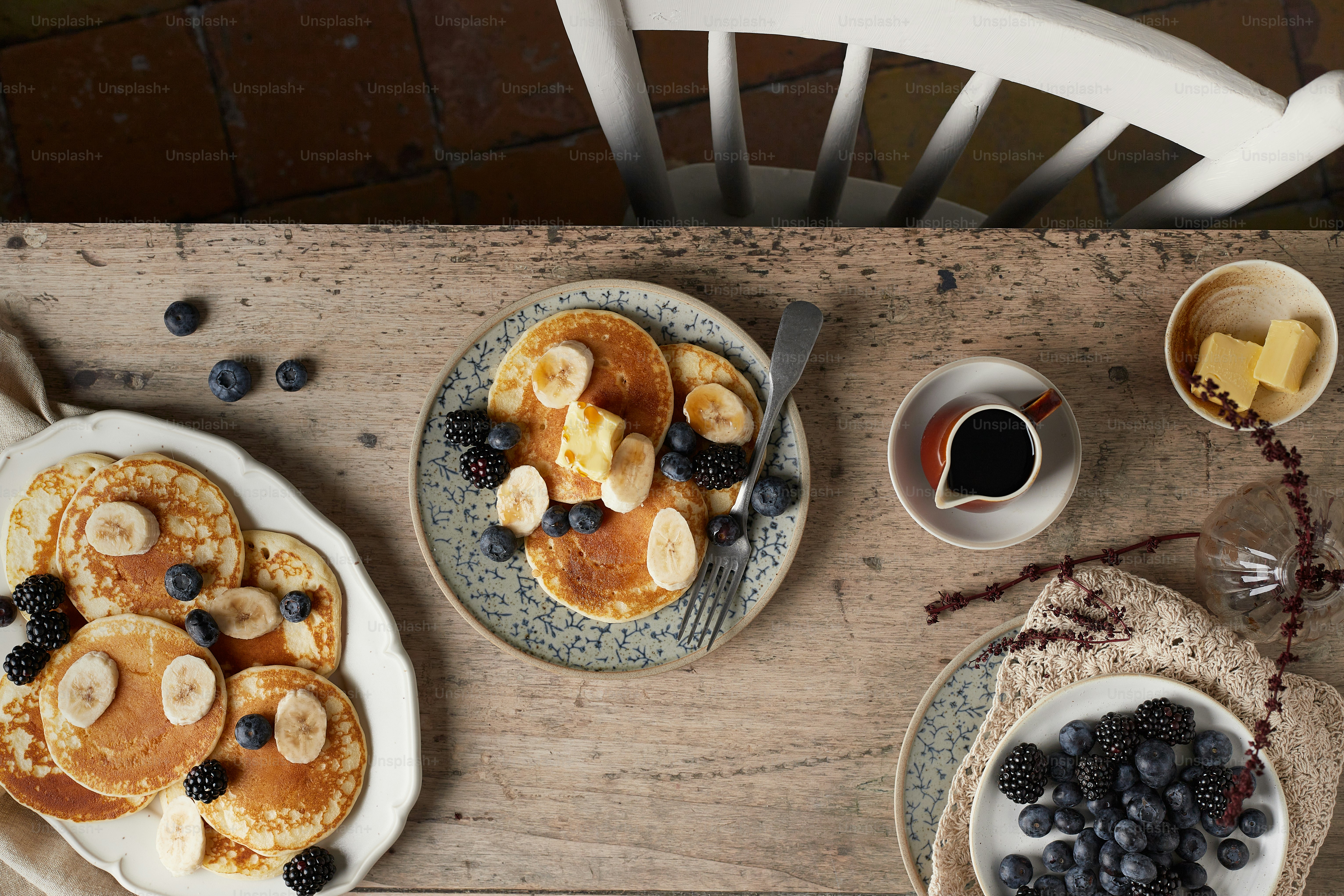 A table topped with pancakes and fruit next to a cup of coffee photo ...