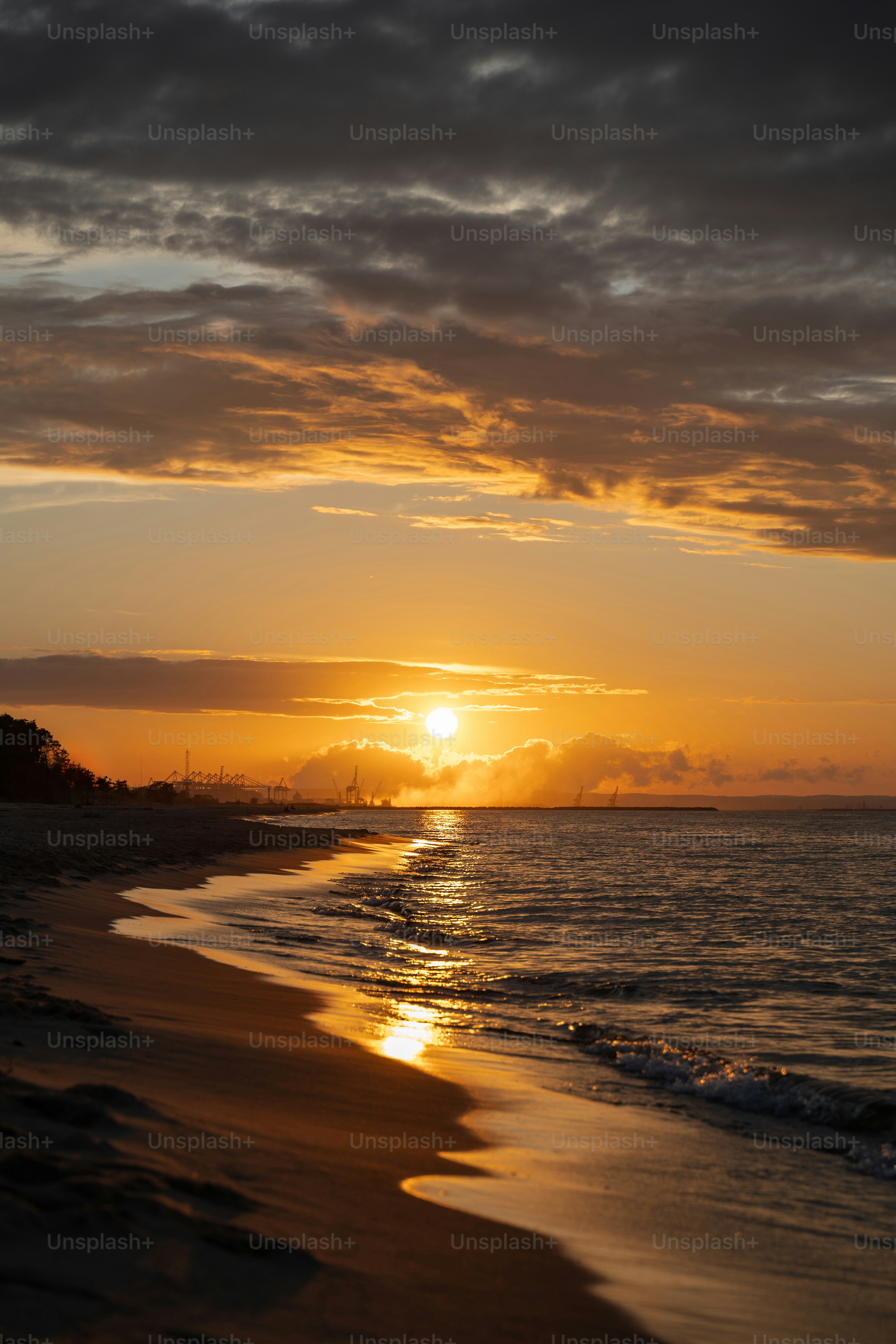 The sun is setting over the water at the beach photo – Wallpaper Image ...