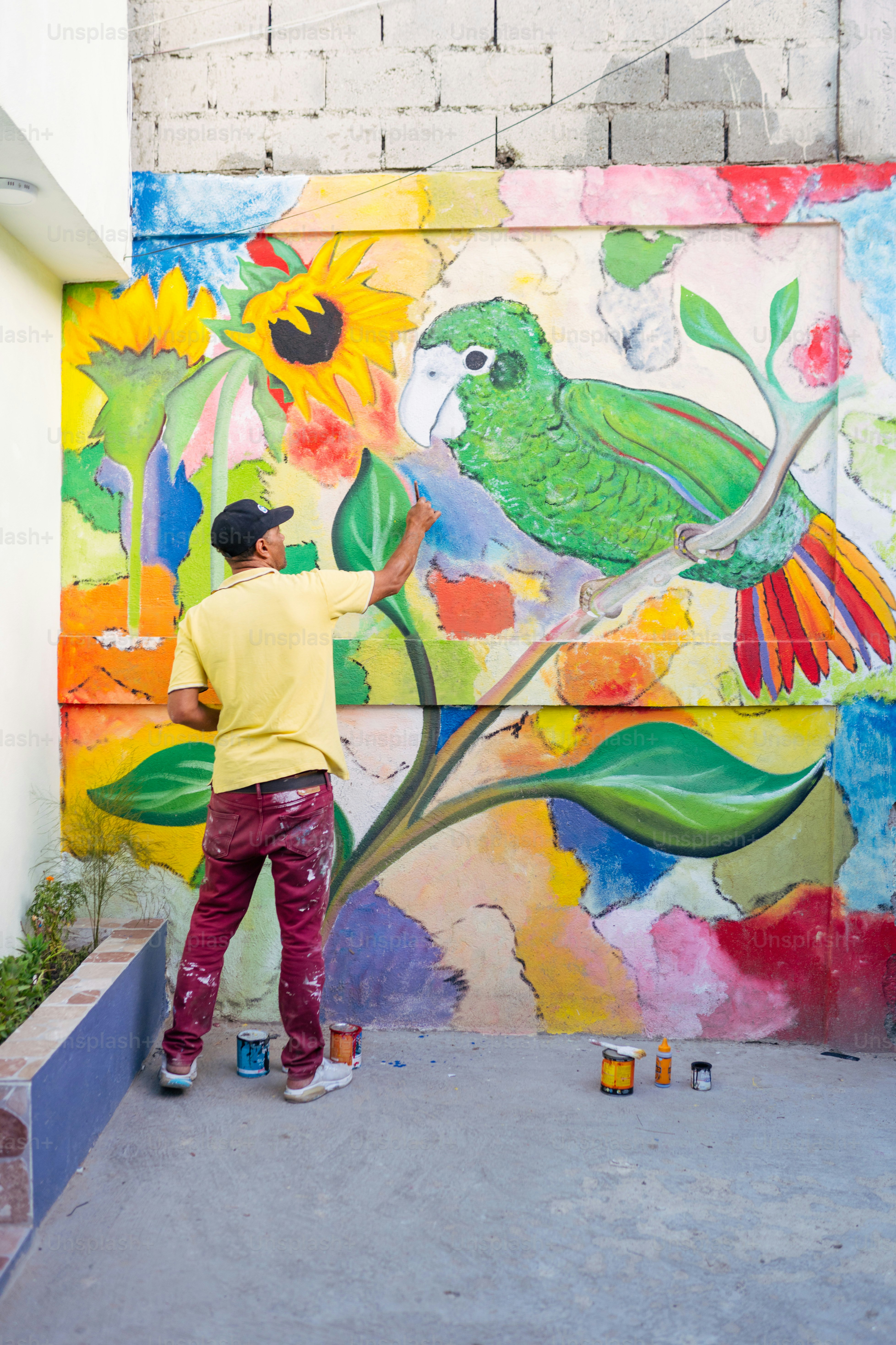 Foto Un hombre pintando un mural en el costado de un edificio – Mural ...