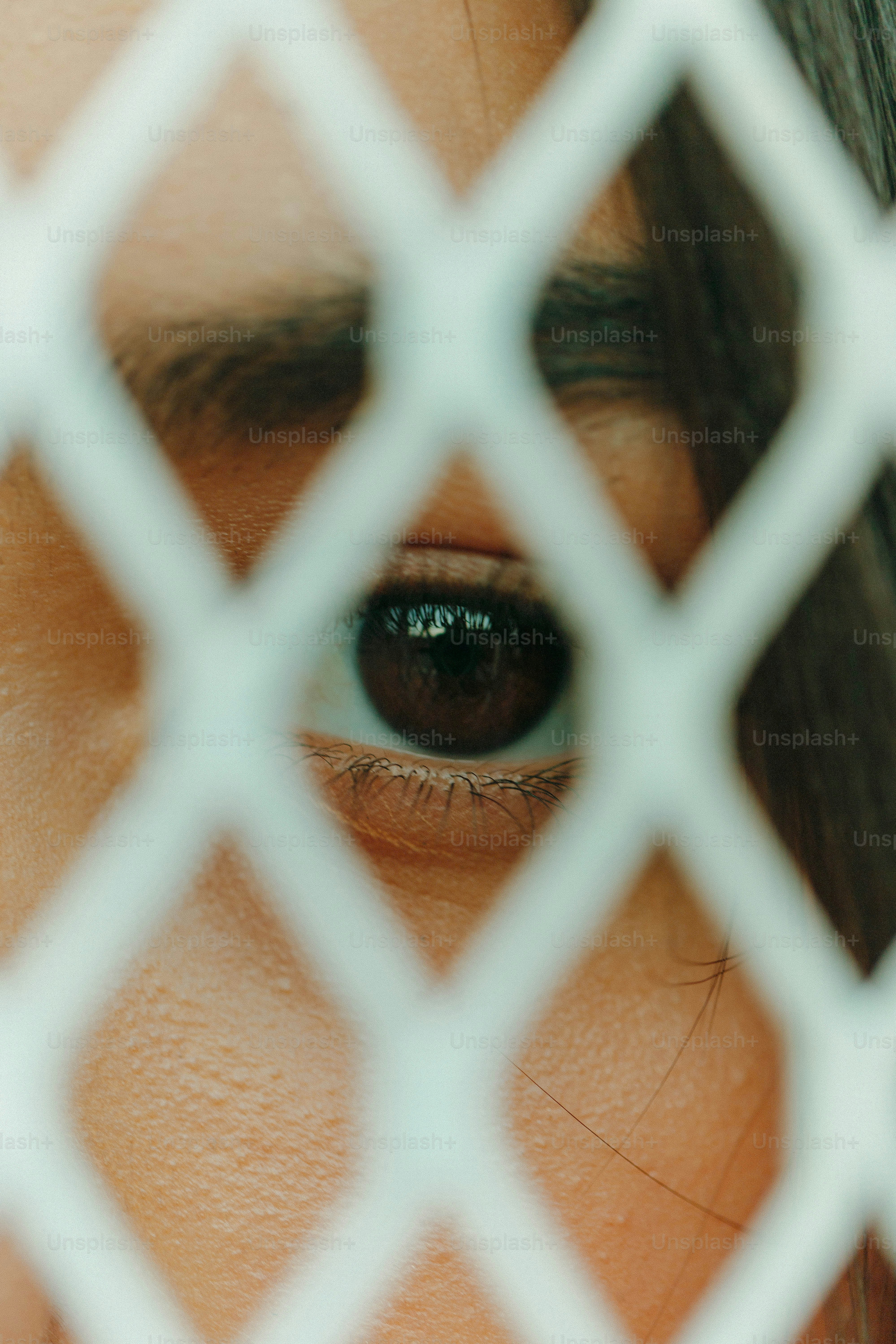 A close up of a person's eye through a chain link fence photo – Eyeball ...