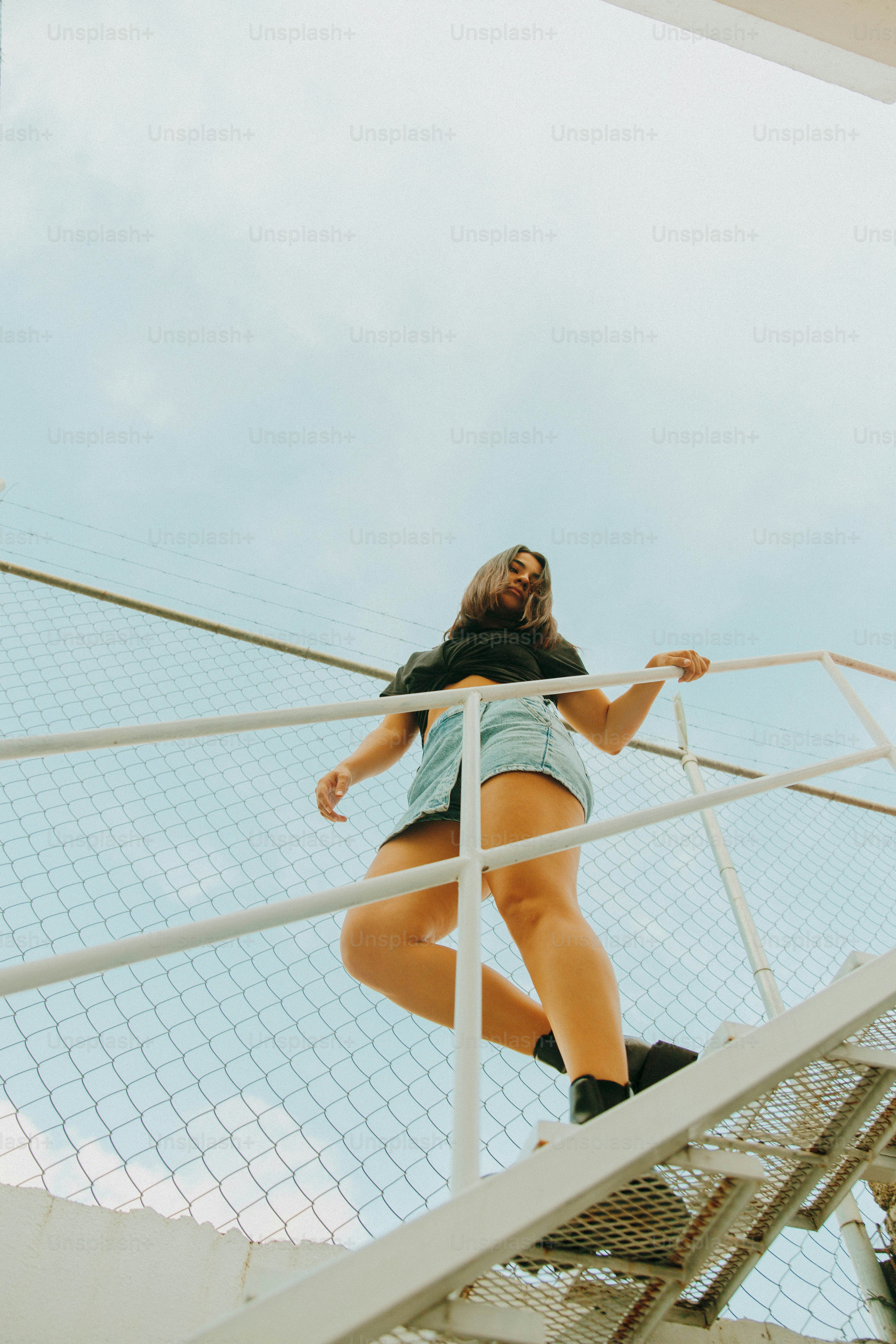 A woman in short shorts walking up a set of stairs photo – End of ...