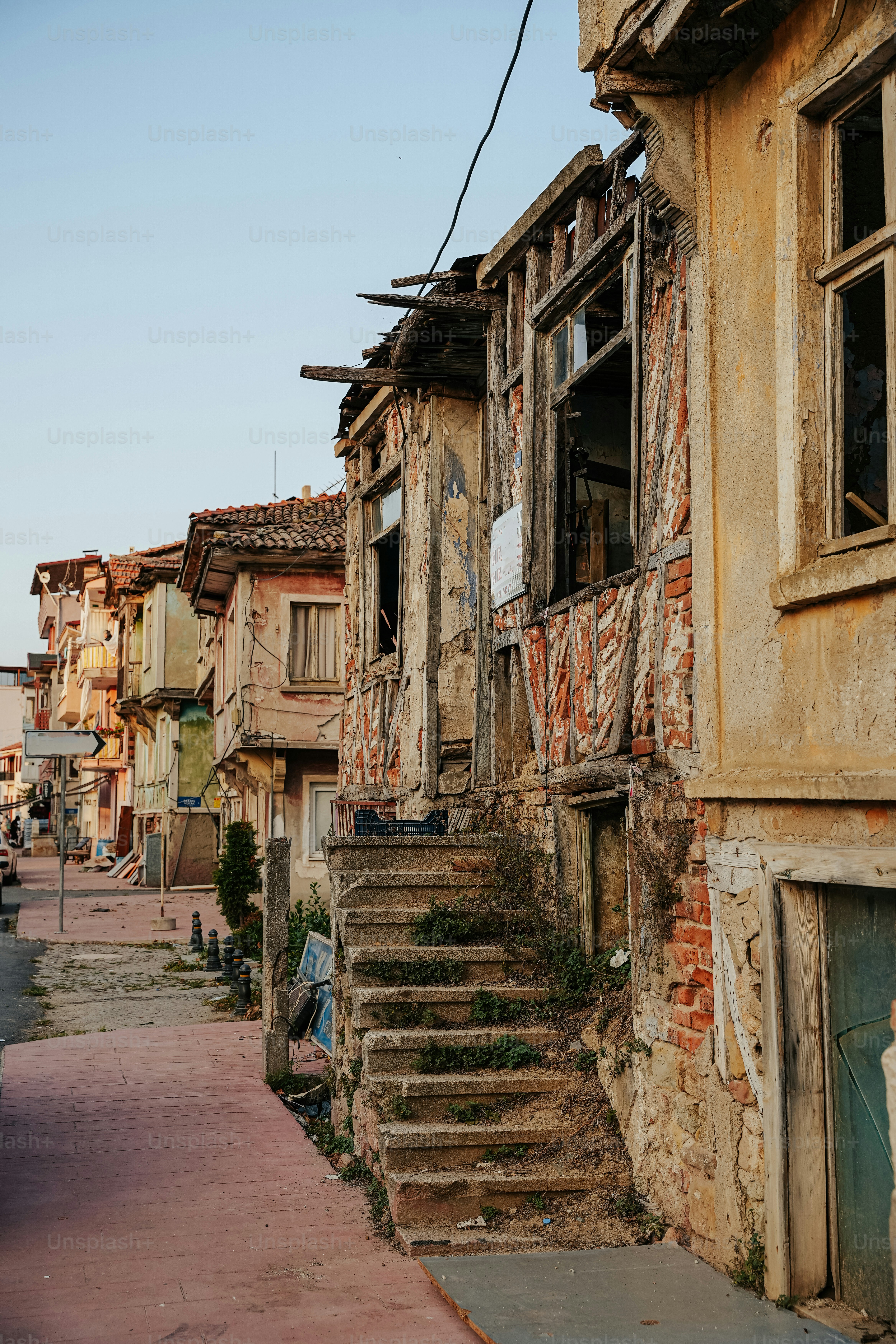 An old run down building with a tree in front of it photo – Poverty ...