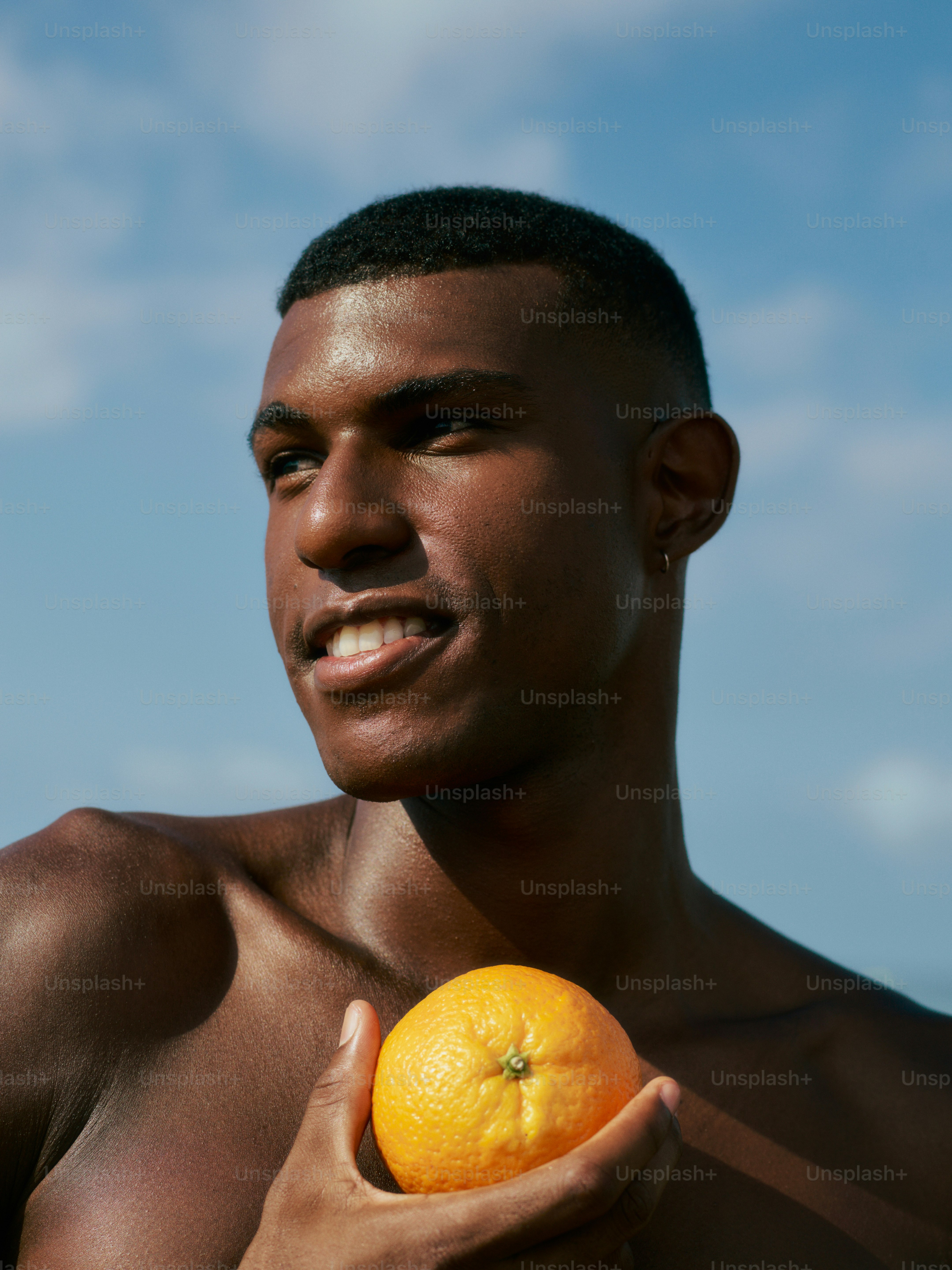 A man holding an orange in his right hand photo – Beach Image on Unsplash