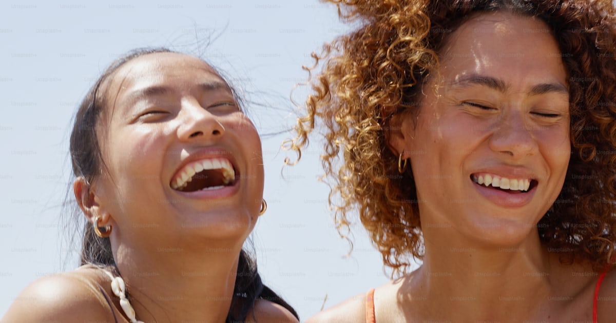 Deux Femmes Assises Sur La Plage Riant Photo Image De Relation