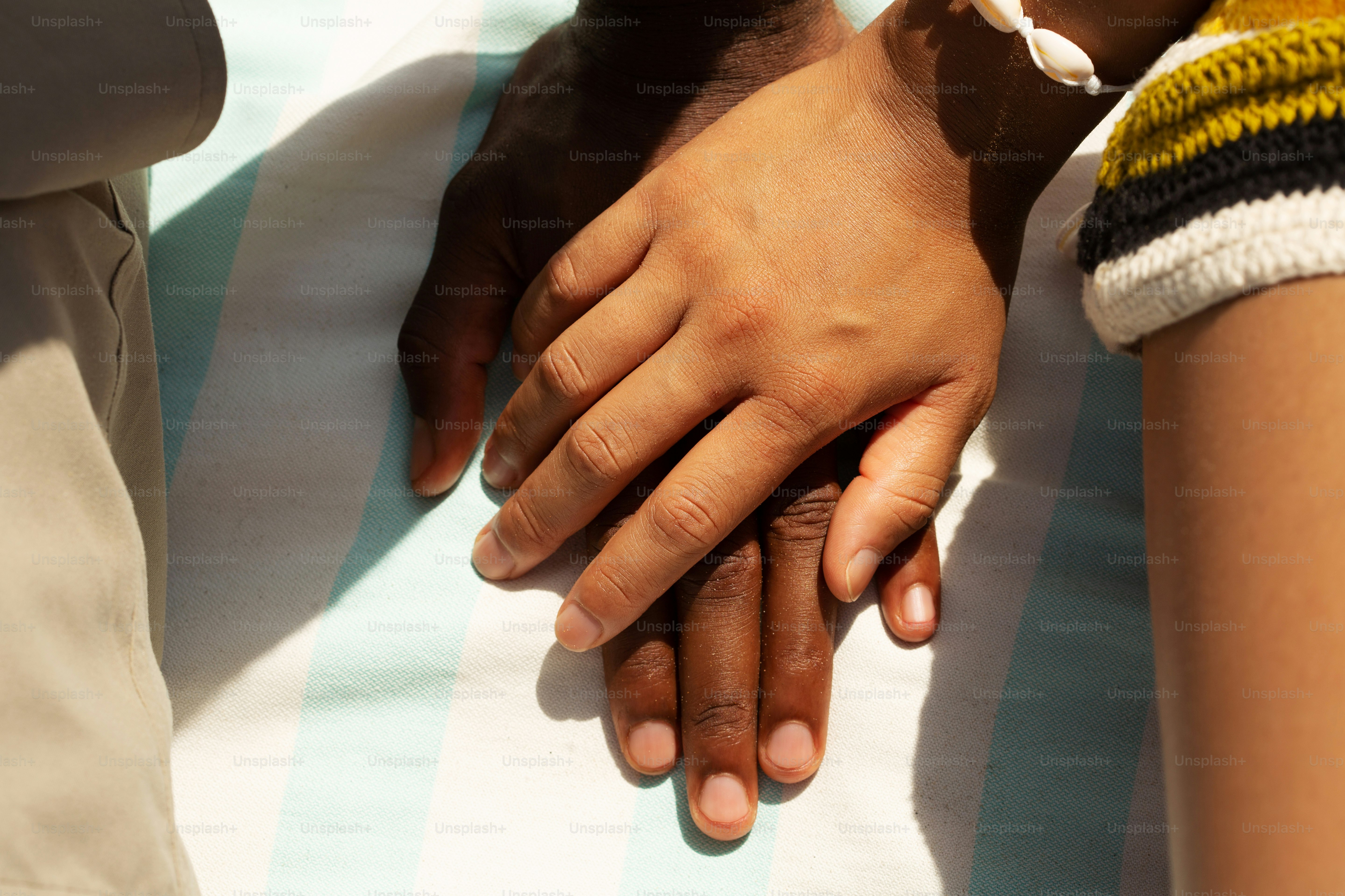 A close up of two people holding hands photo – Couple Image on Unsplash