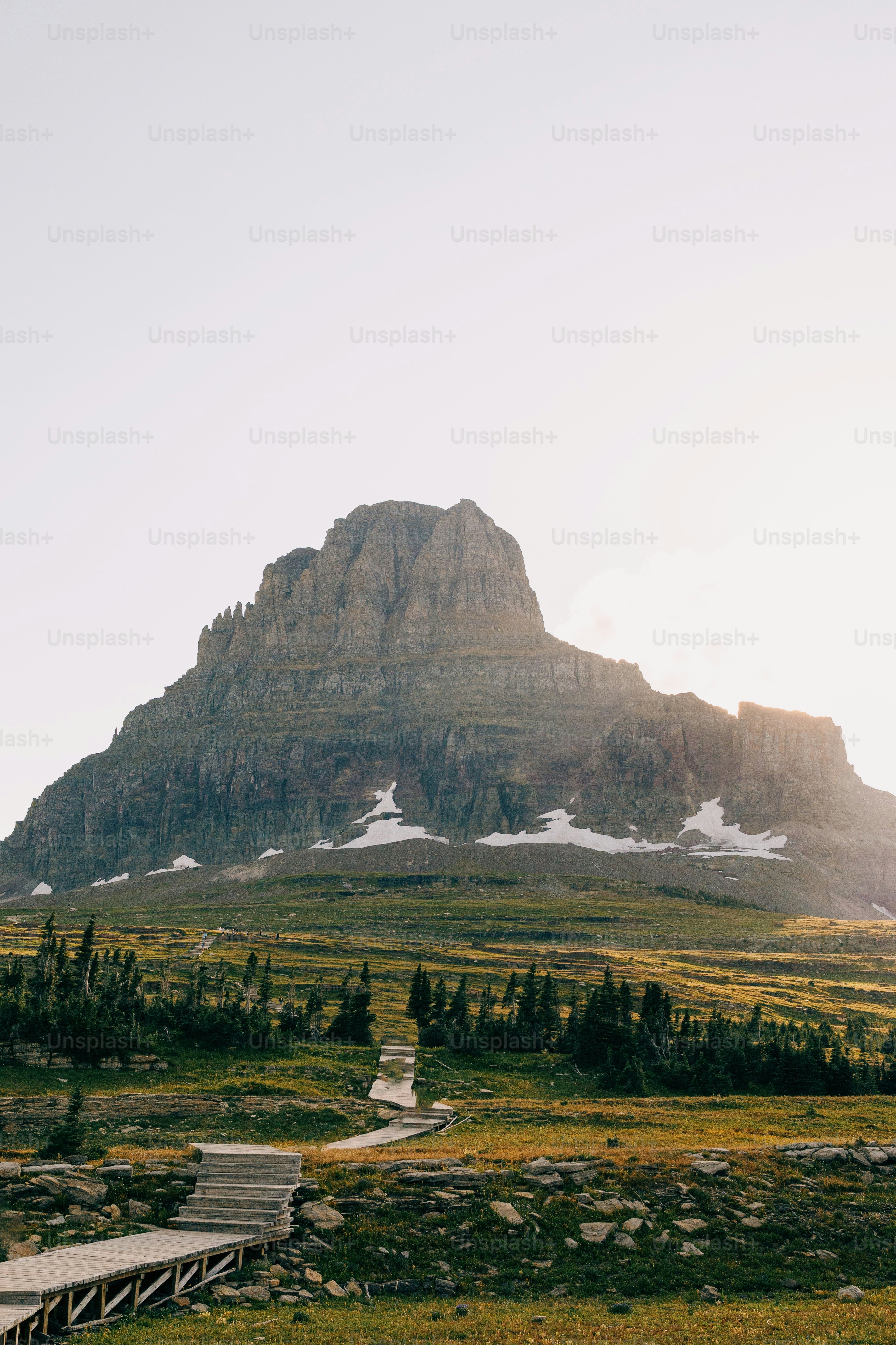 A large mountain is in the distance with a path leading to it photo ...