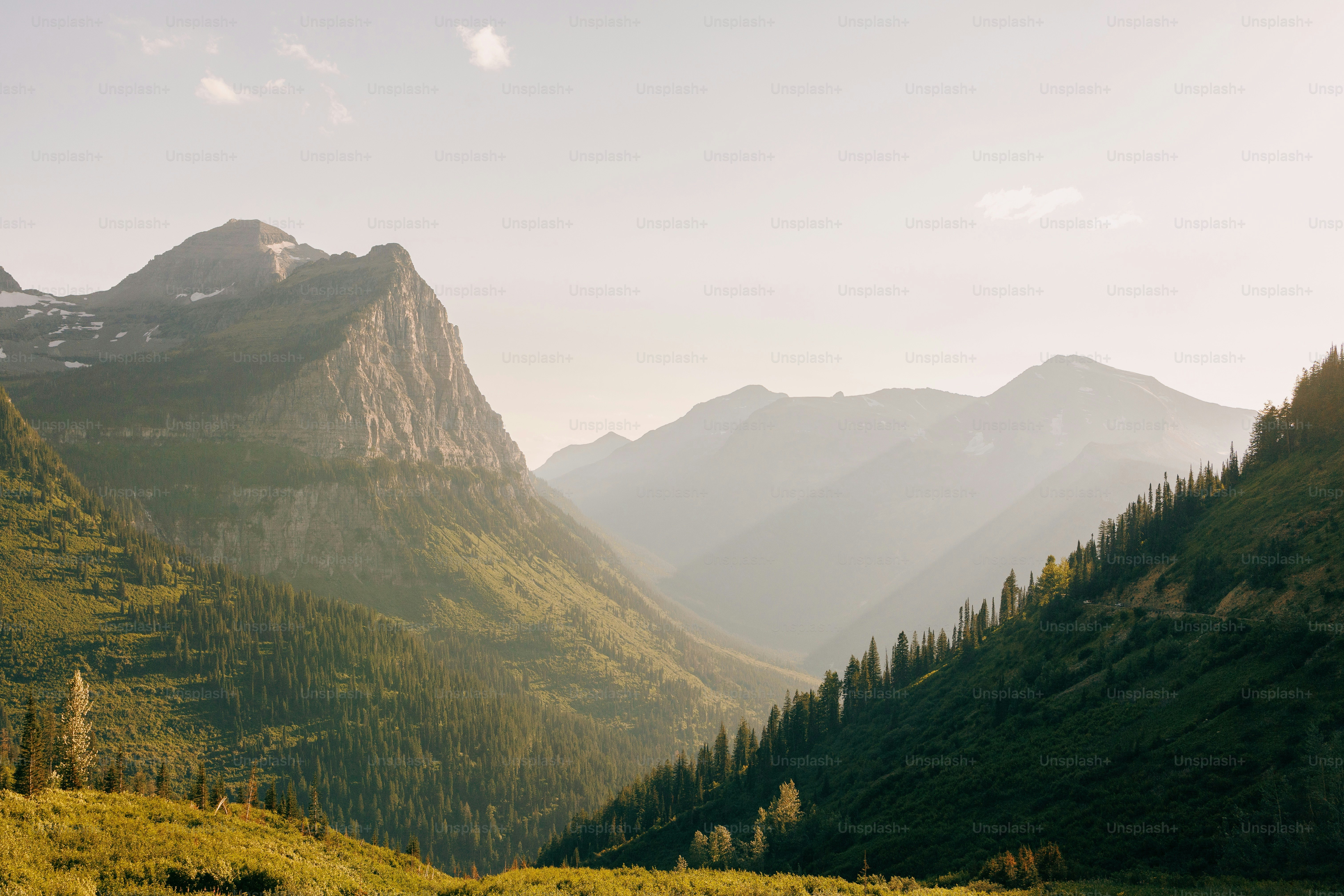 A view of a valley with mountains in the background photo – Glacier ...