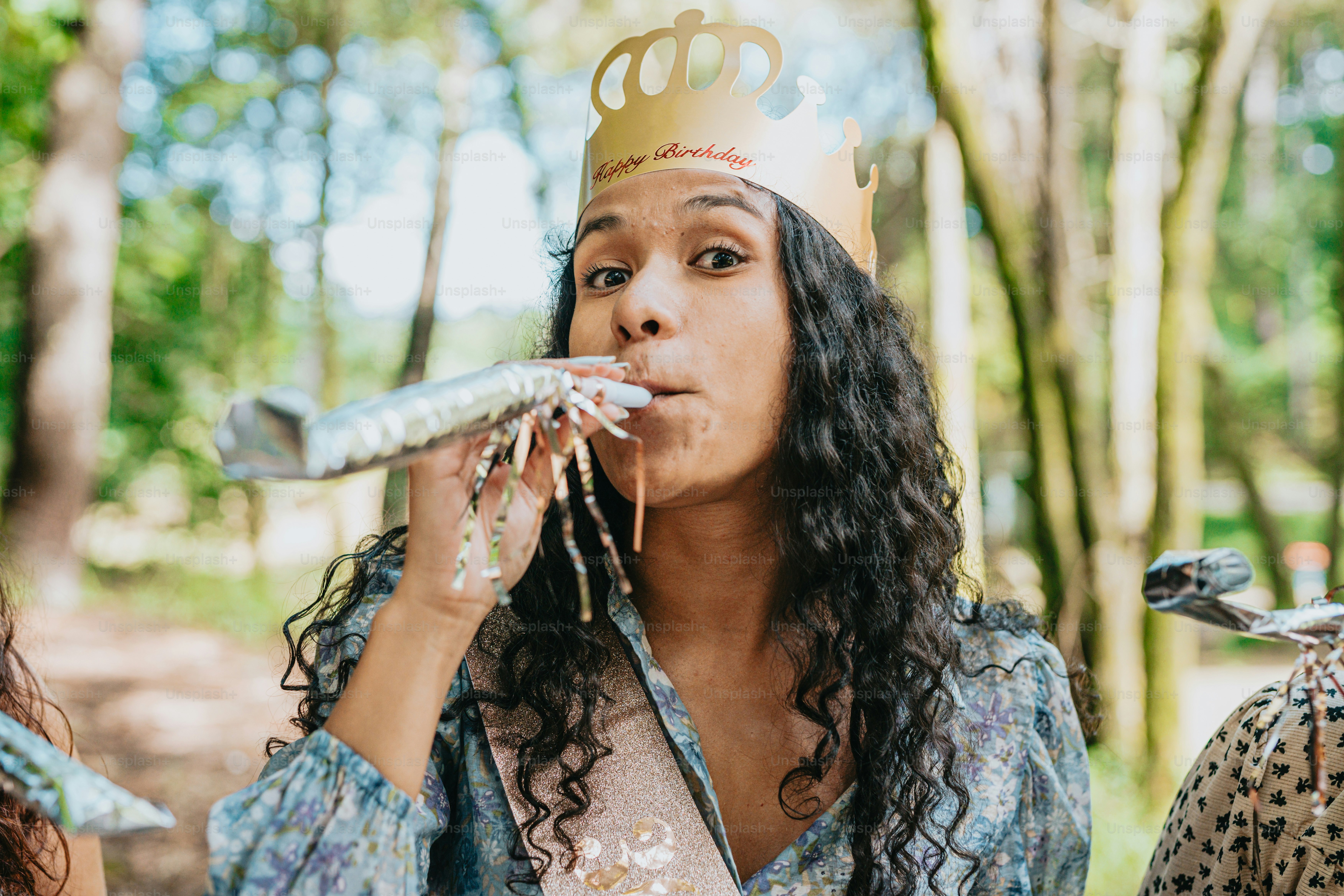 A woman with a crown on her head eating a hot dog photo – Party Image ...