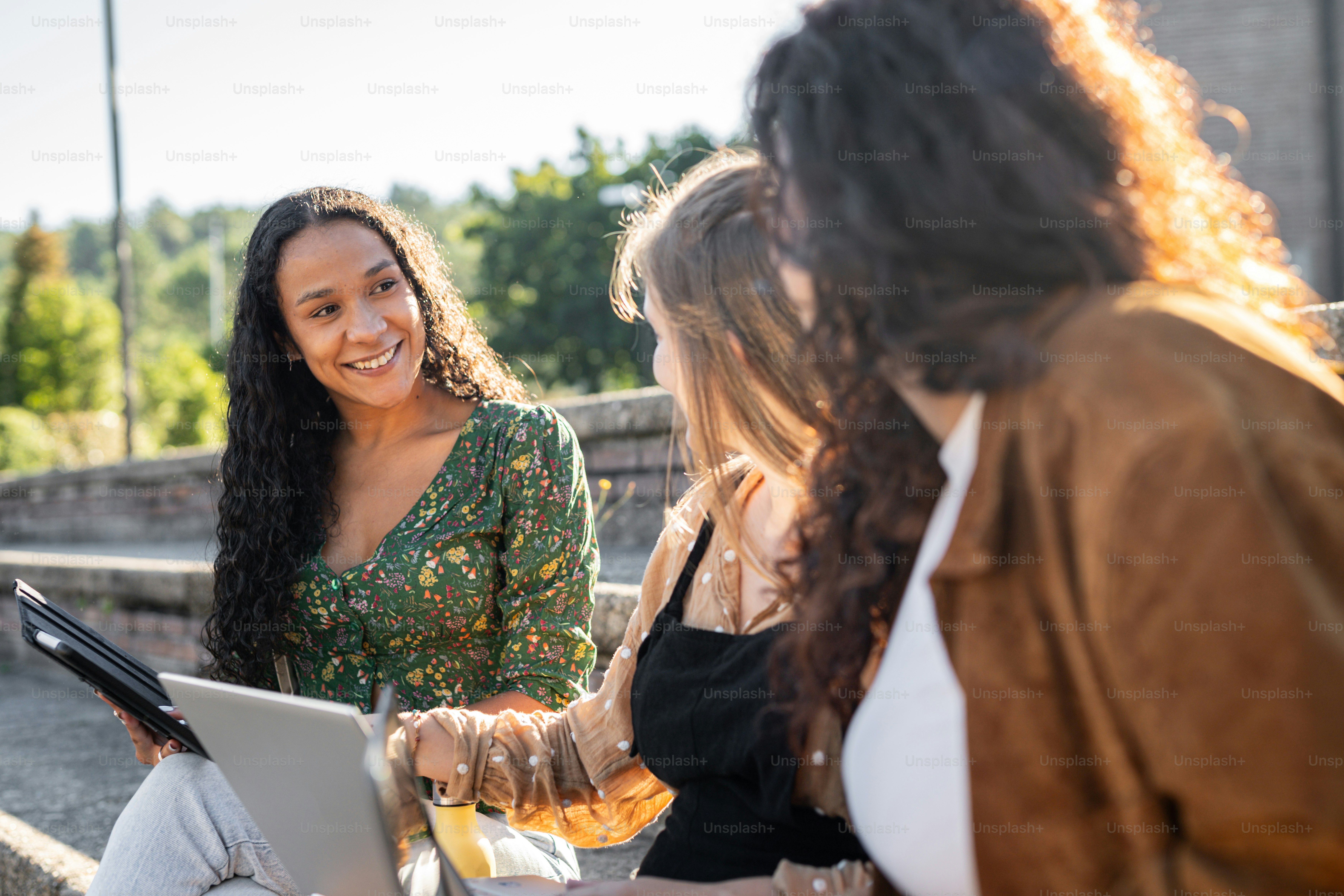 A group of women standing around a laptop computer photo – College ...