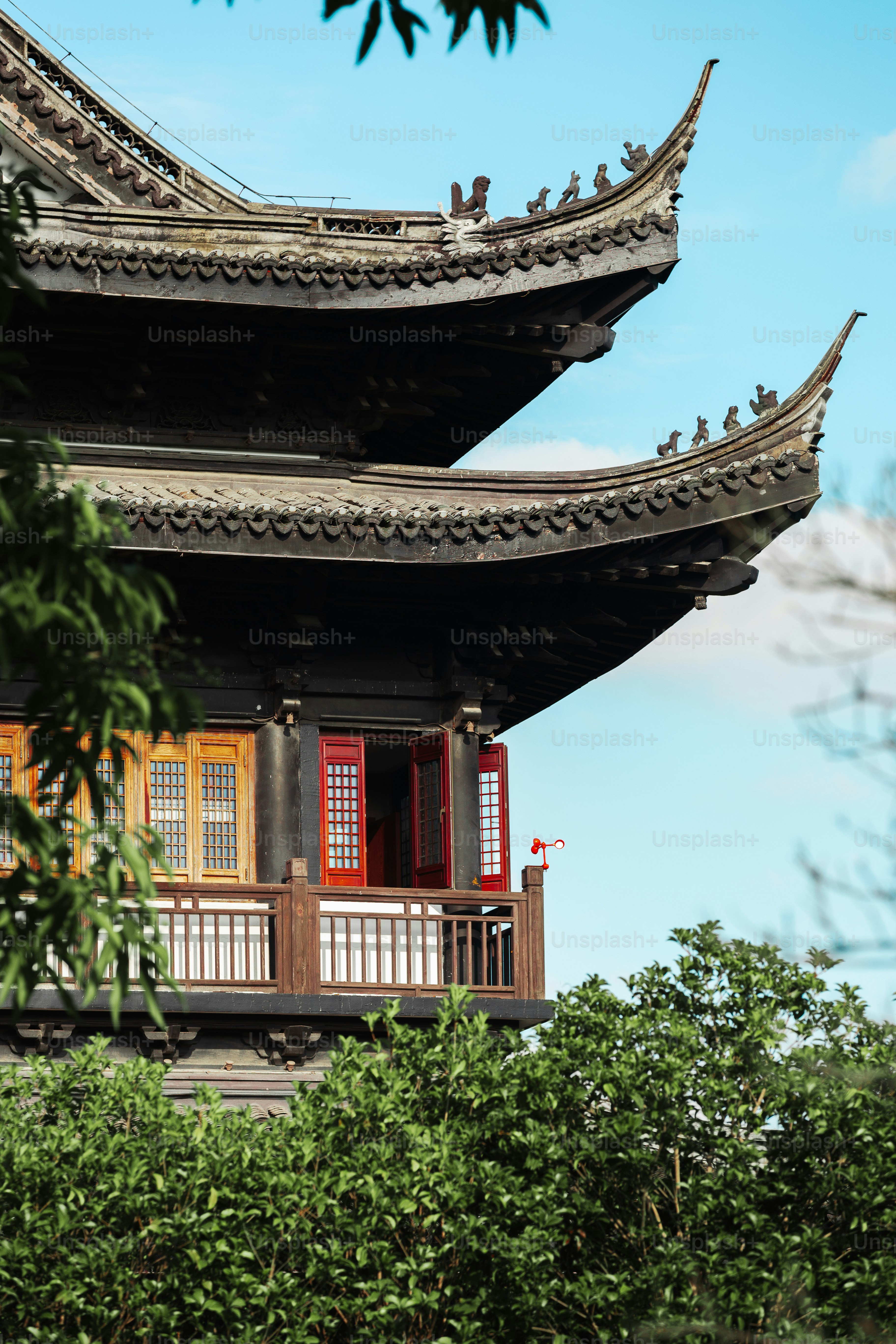 A tall building with a red door and a balcony photo – Building Image on ...