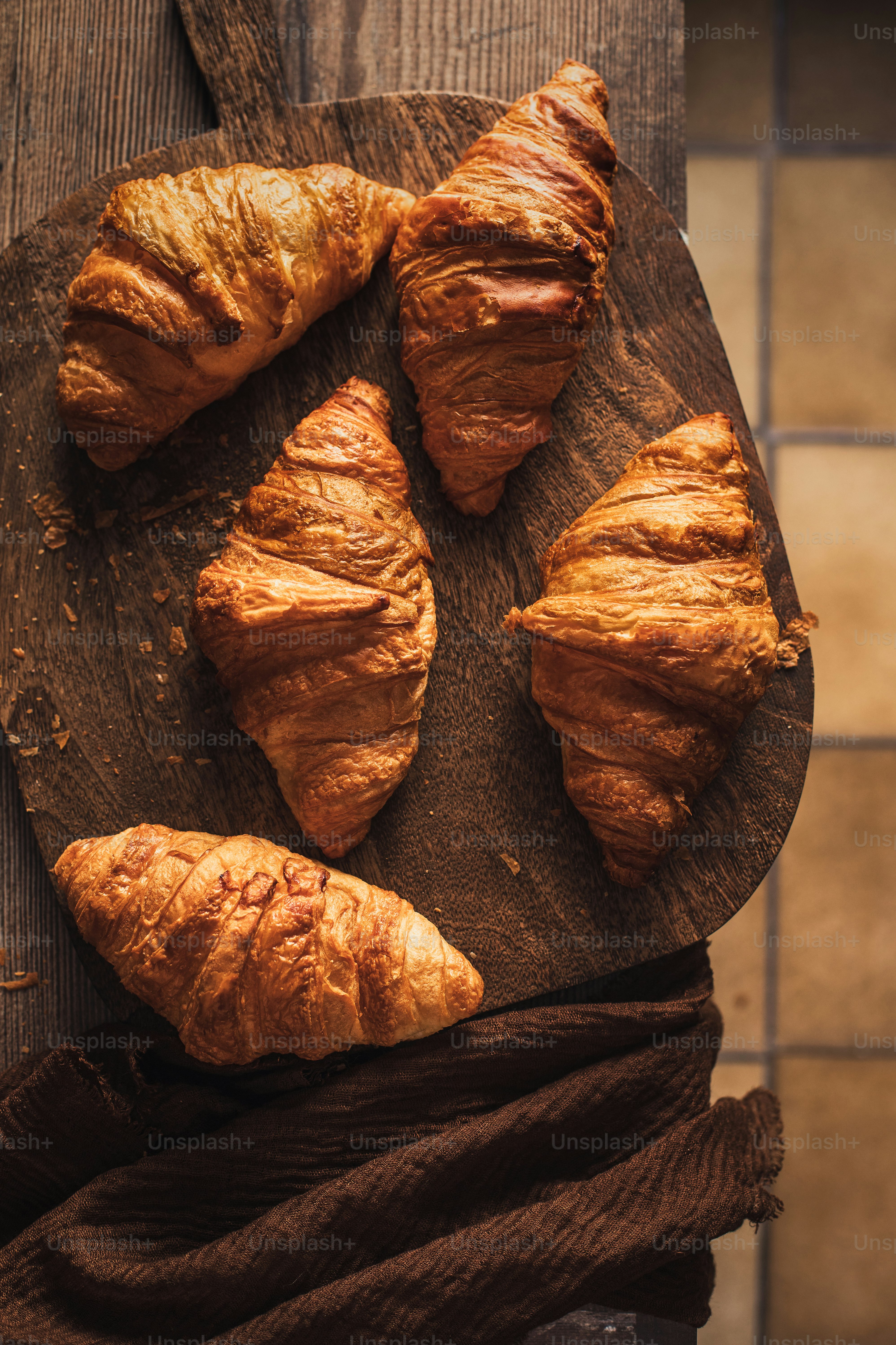 Croissants and a piece of bread on a wooden board photo – Freshly baked ...