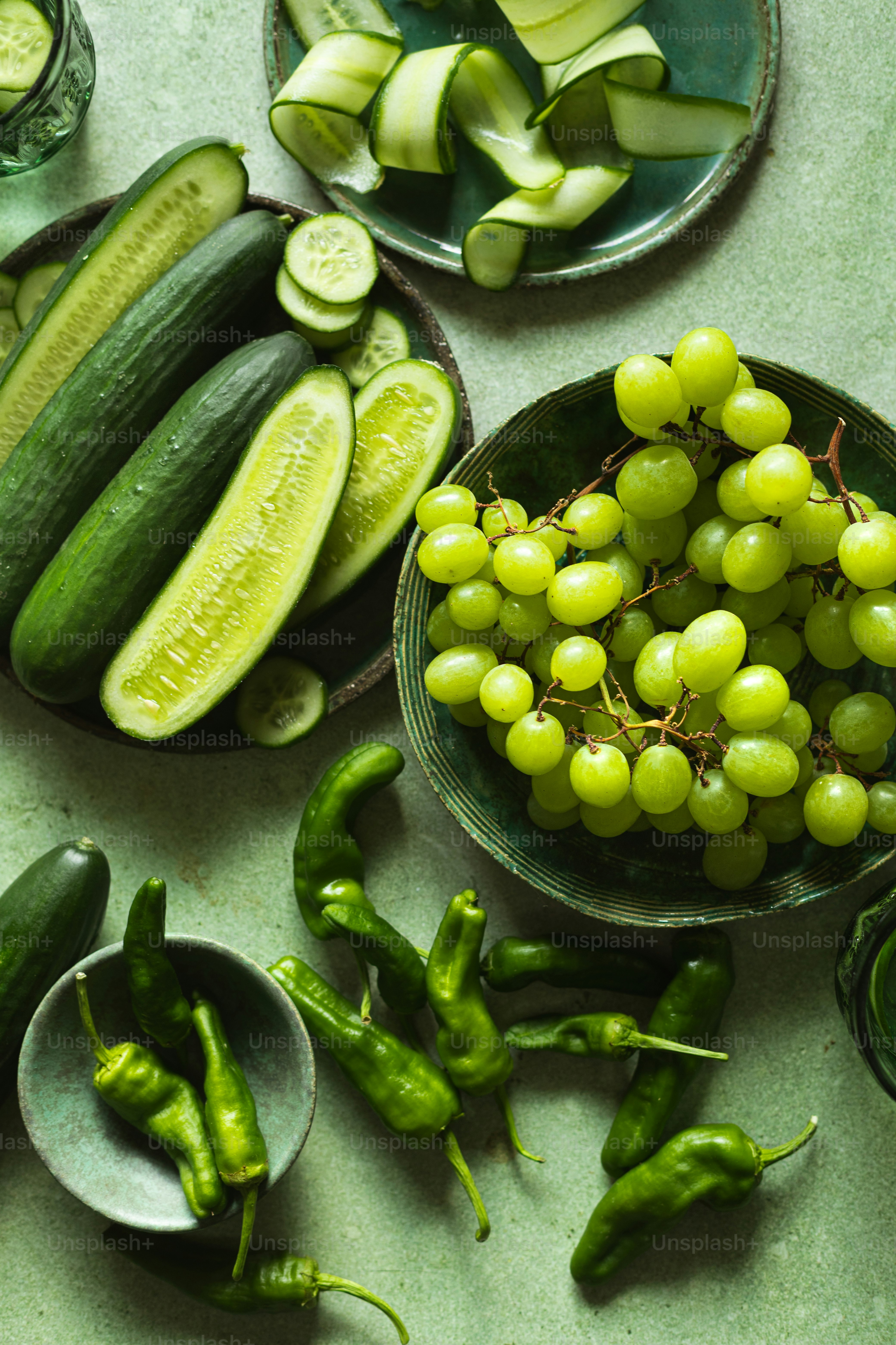 A table topped with bowls of green vegetables photo – Grapes Image on ...