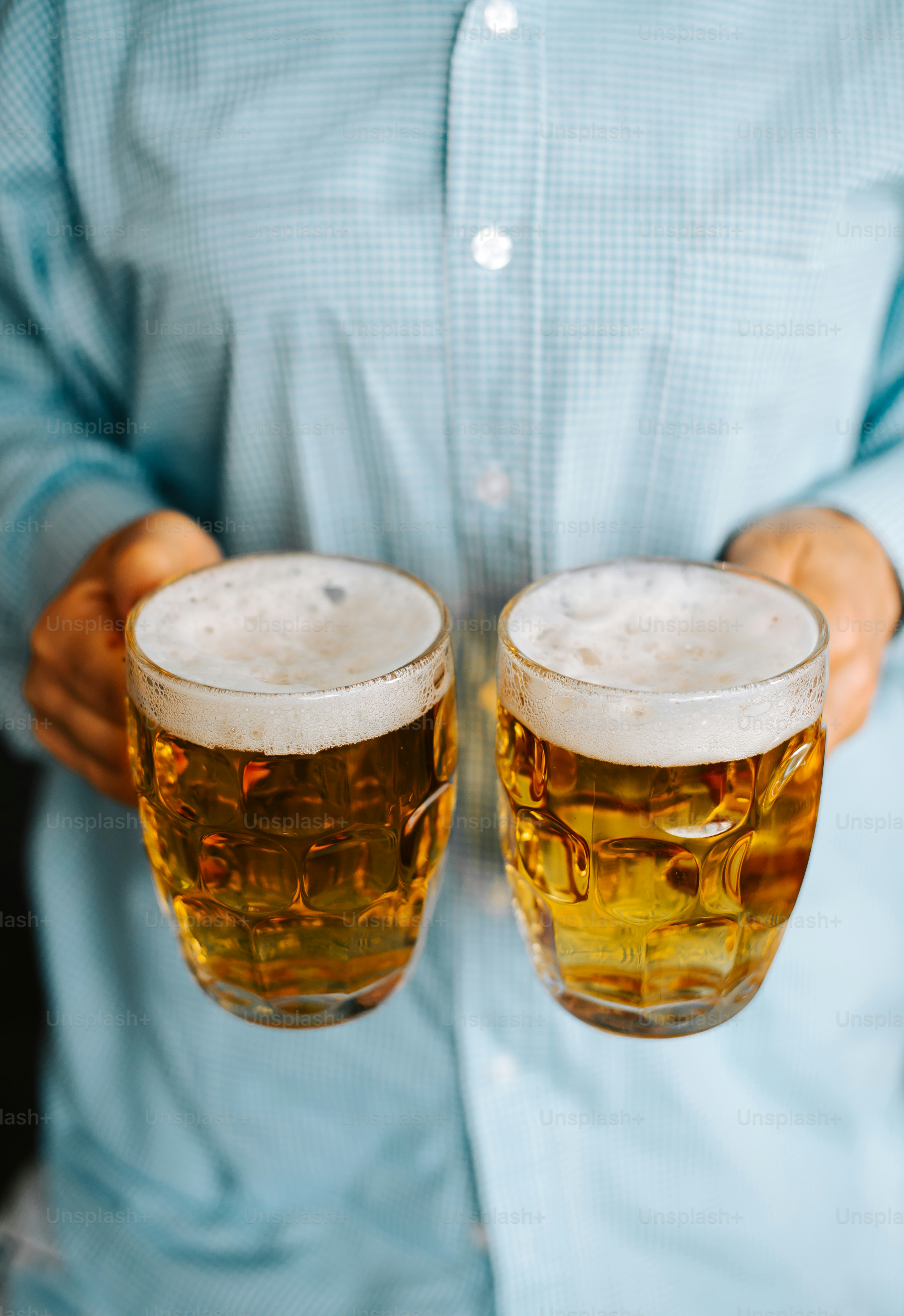 A man holding two glasses of beer in his hands photo – Octoberfest ...