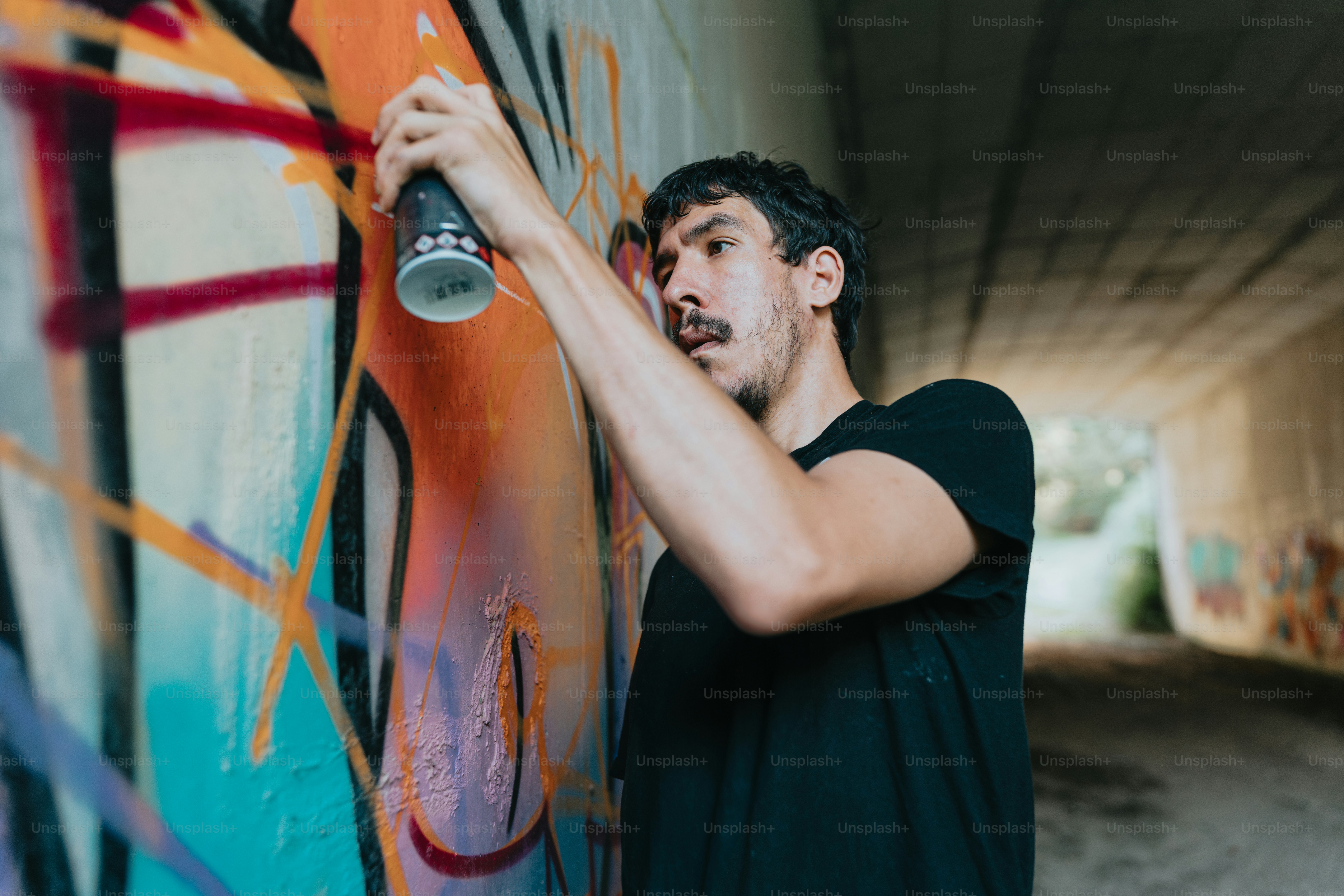 A man spray painting a wall with graffiti photo – Art Image on Unsplash