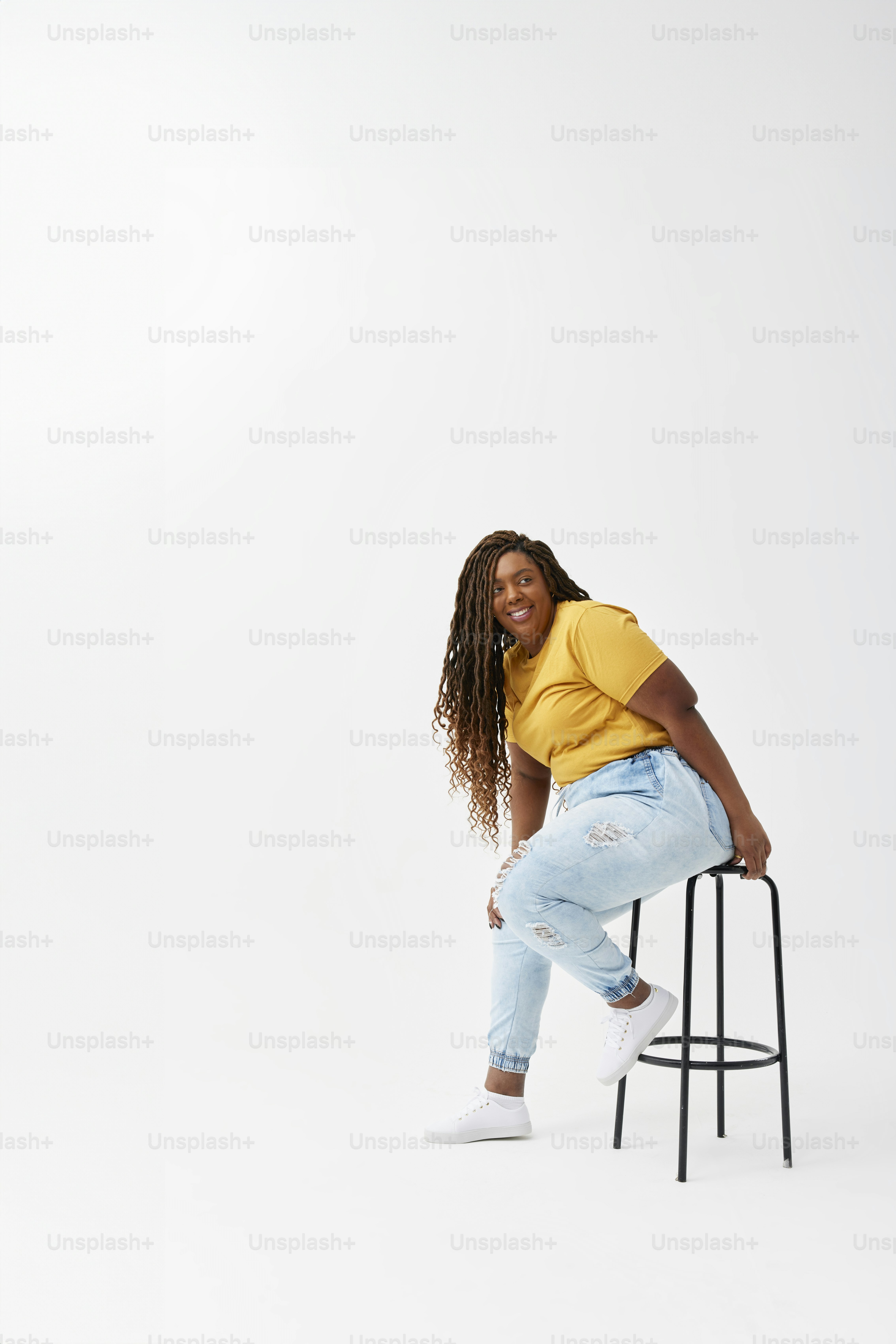 A woman sitting on a stool posing for a picture photo – Fashion Image ...