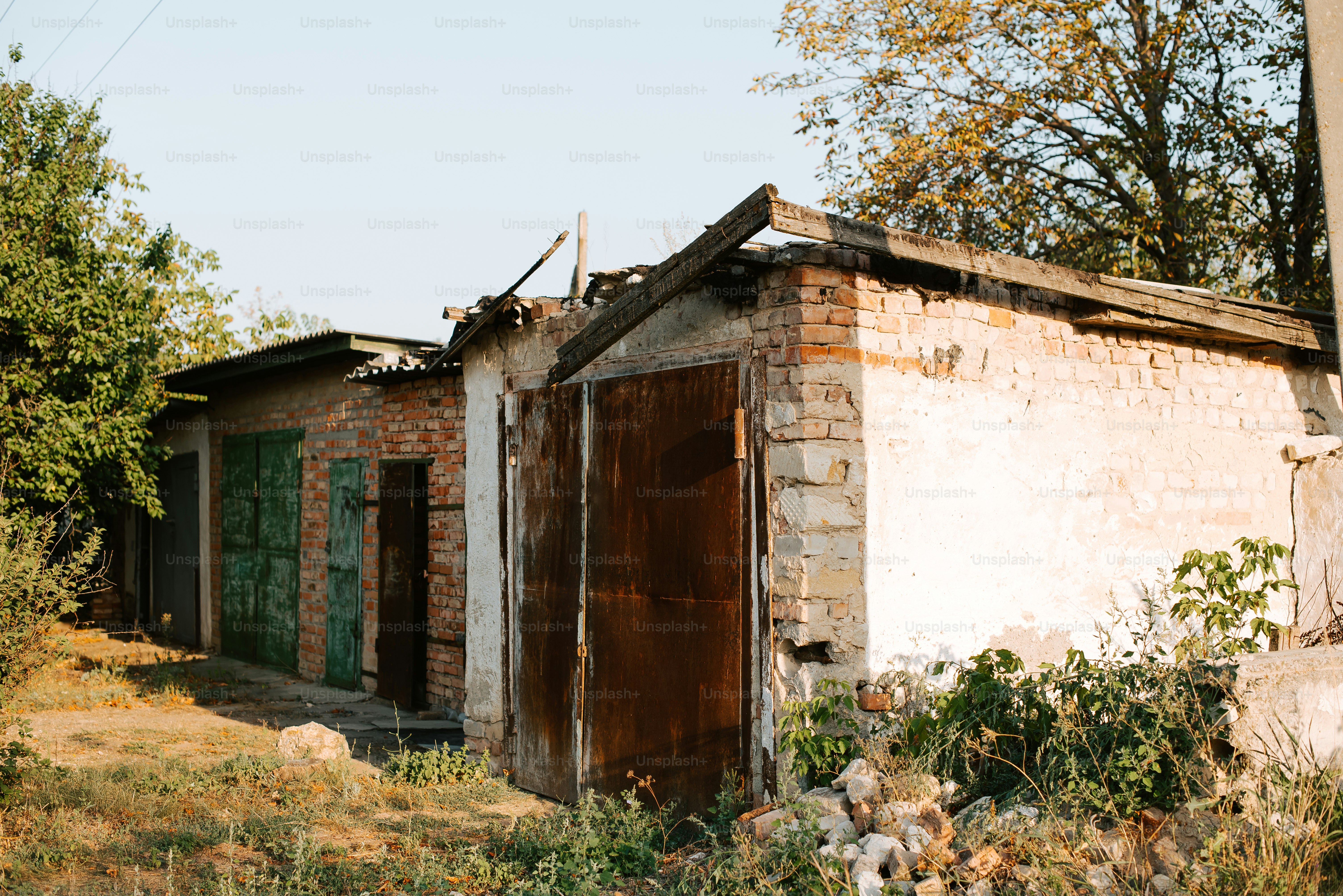 An old run down building with a broken door photo – Homeless Image on ...