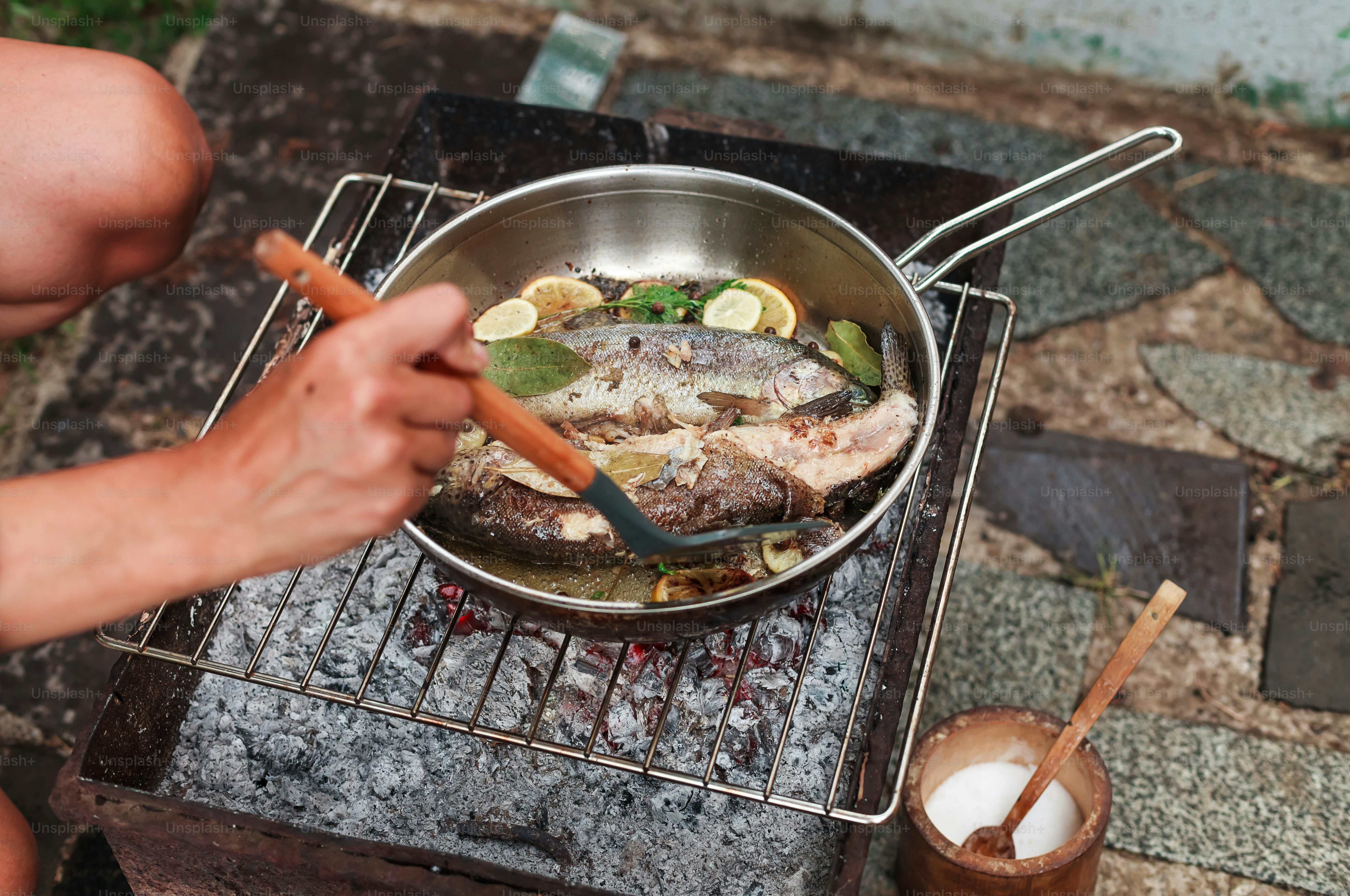 A person is cooking fish on a grill photo – Fish Image on Unsplash