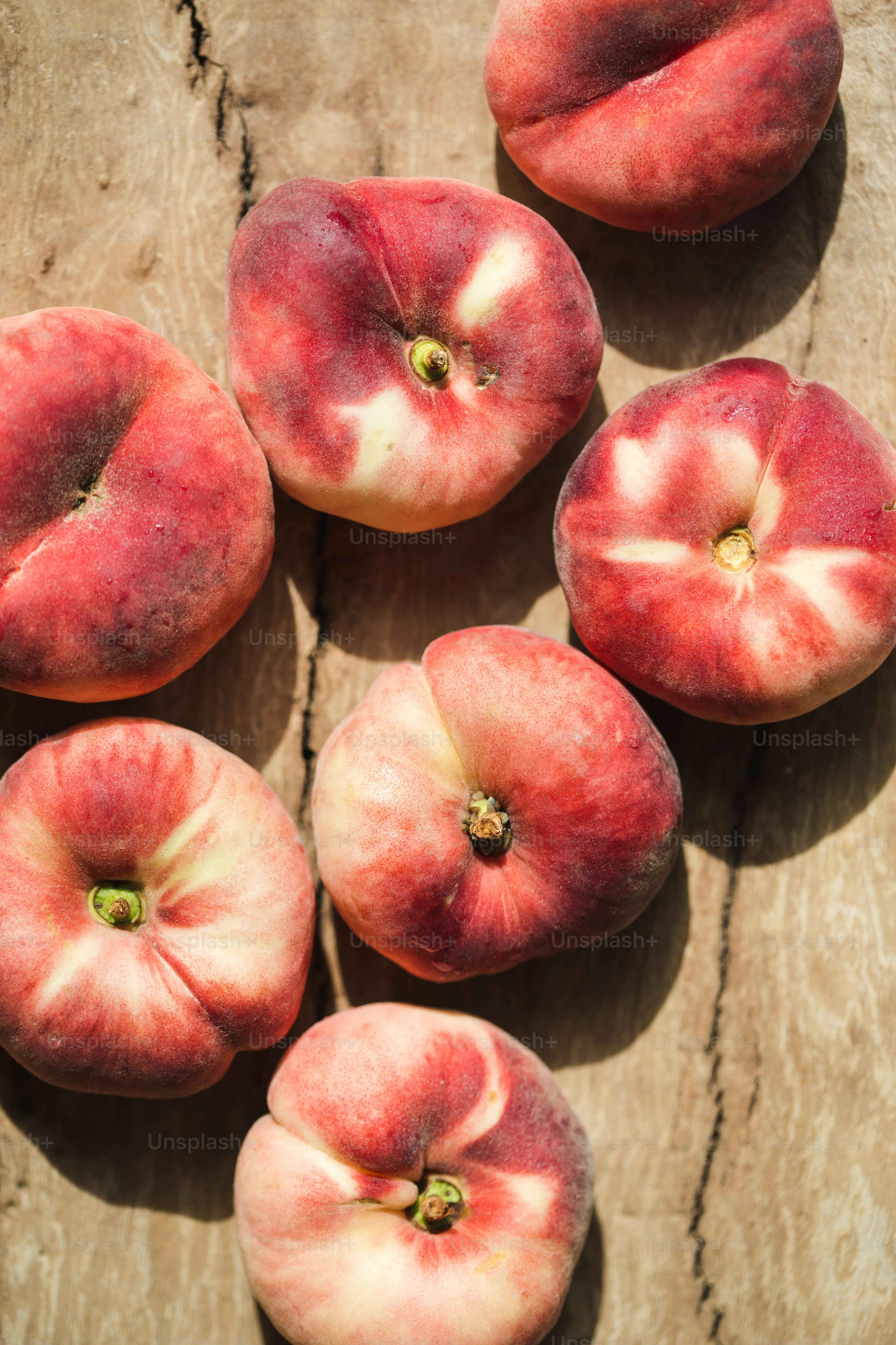 A group of peaches sitting on top of a wooden table photo – Raw peaches ...