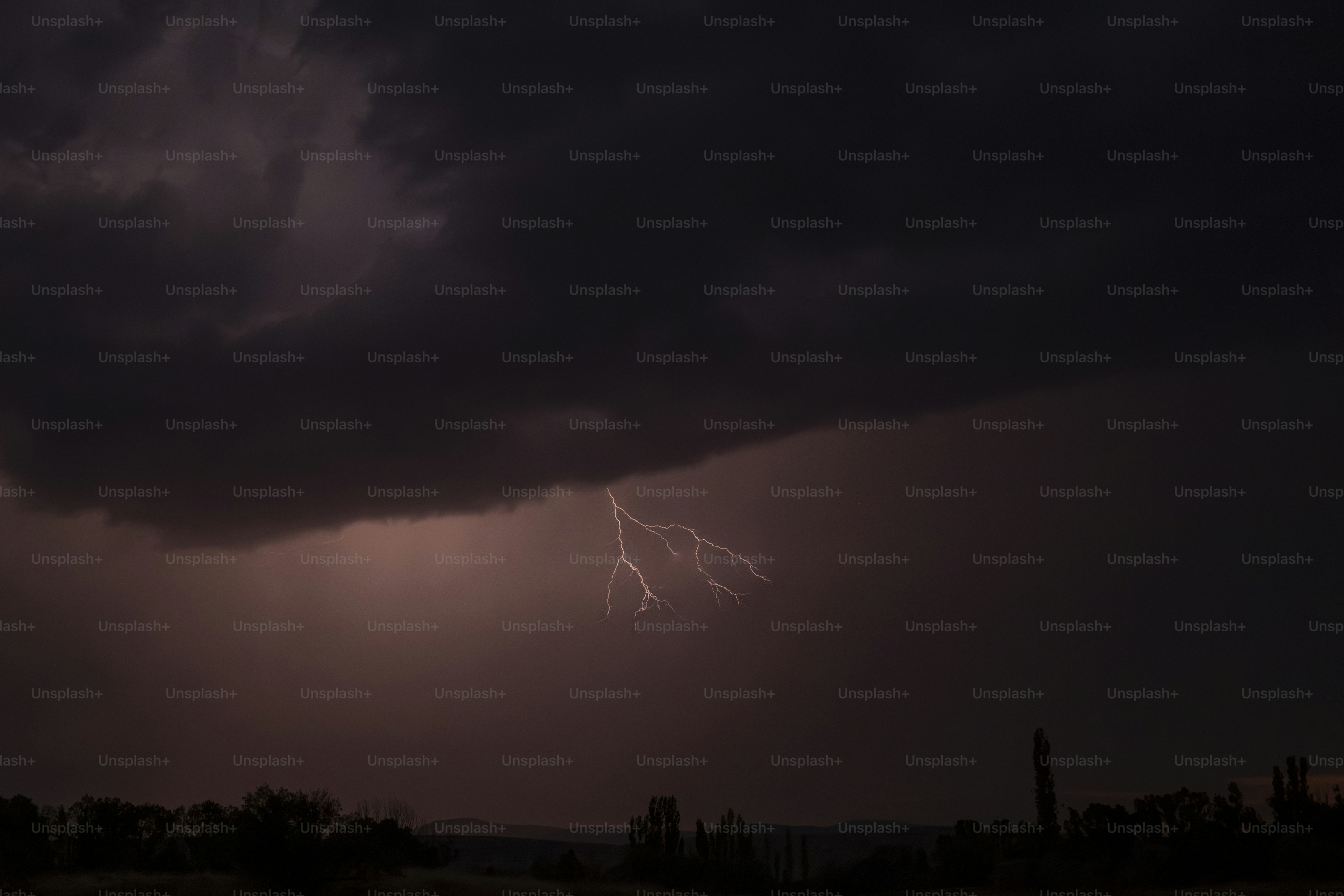 A lightning bolt hitting through a dark sky photo – Nature Image on ...