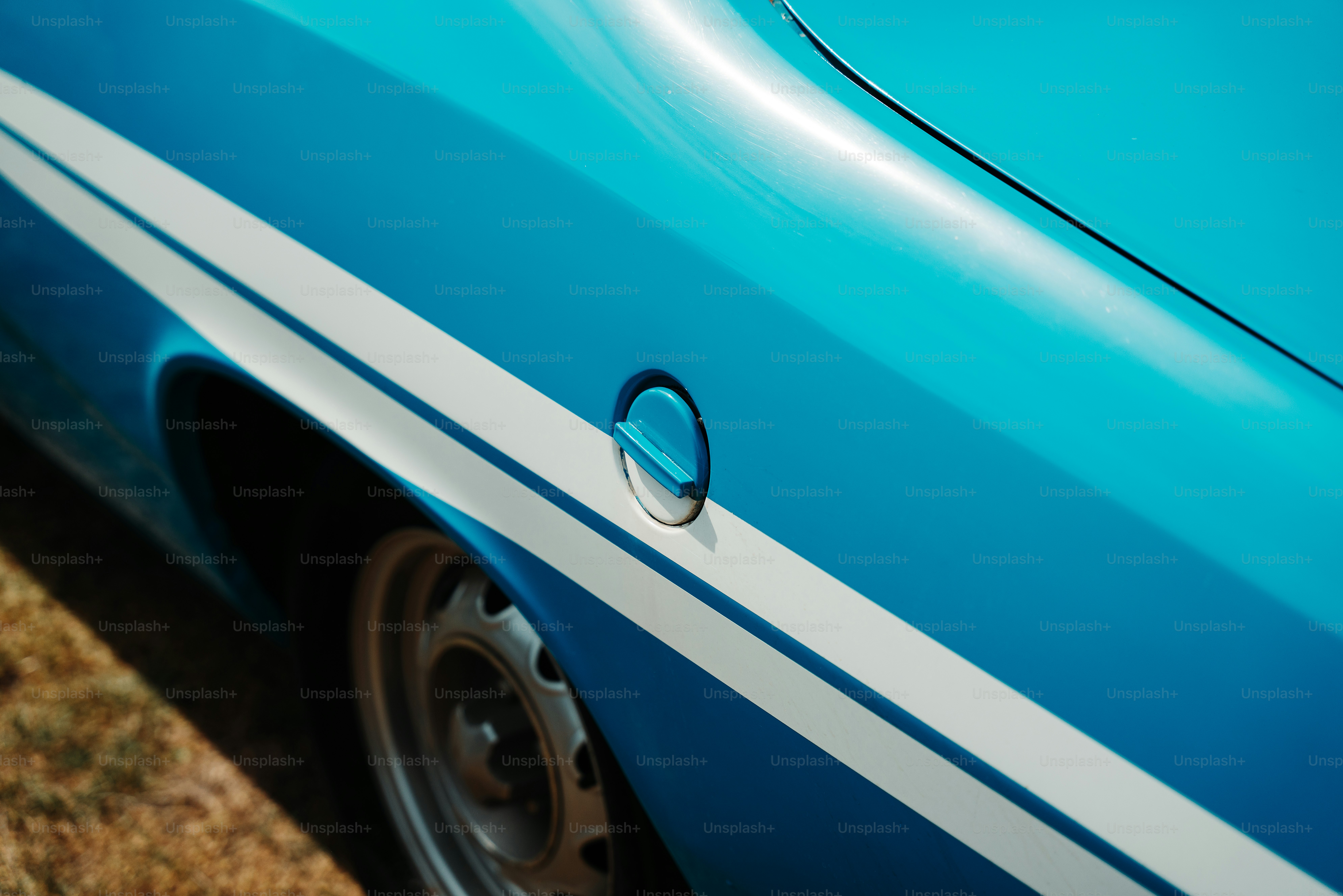A close up of a blue car with white stripes photo – Car Image on Unsplash