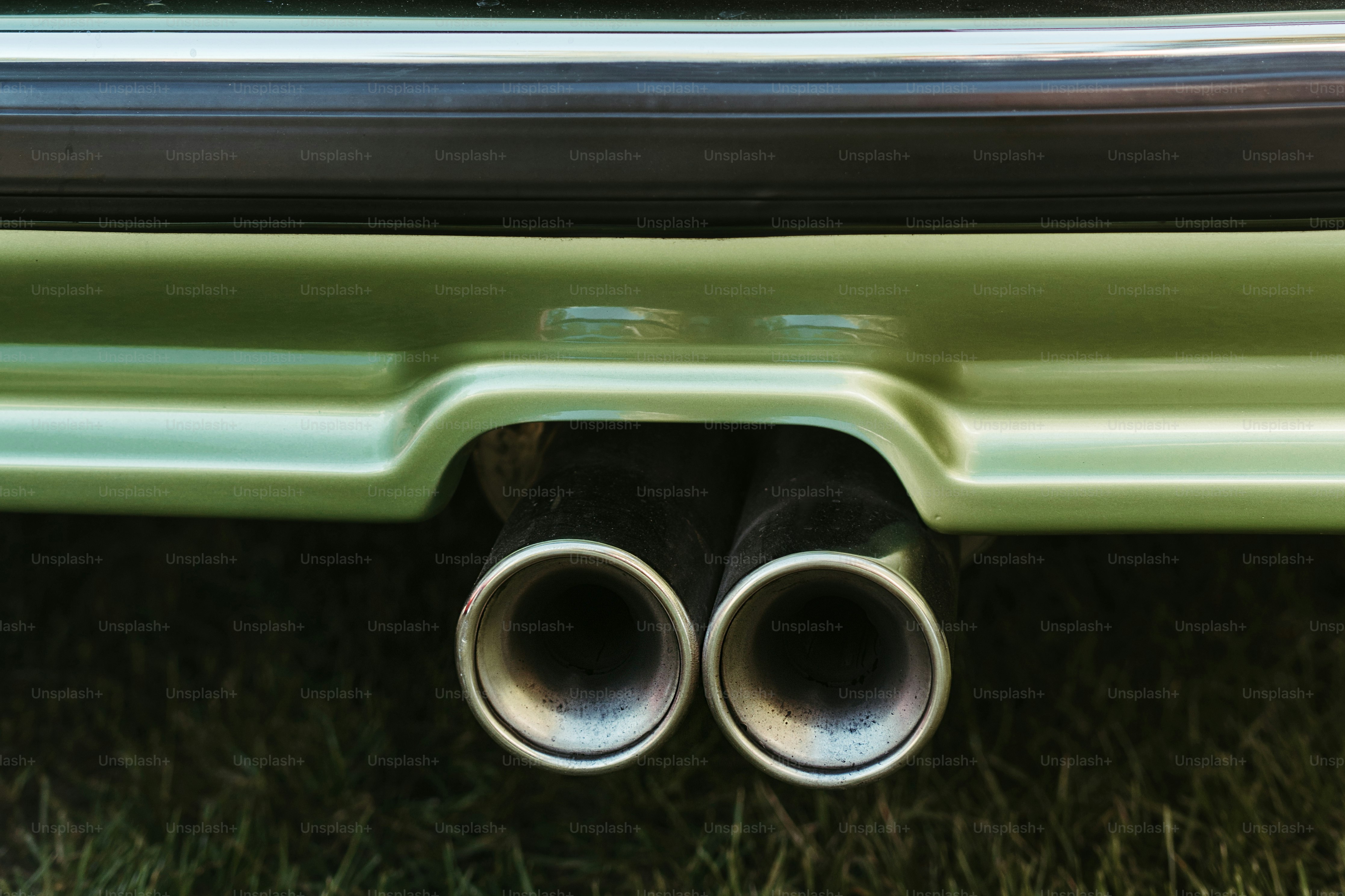 A close up of a green car with two exhaust pipes photo – Car Image on ...